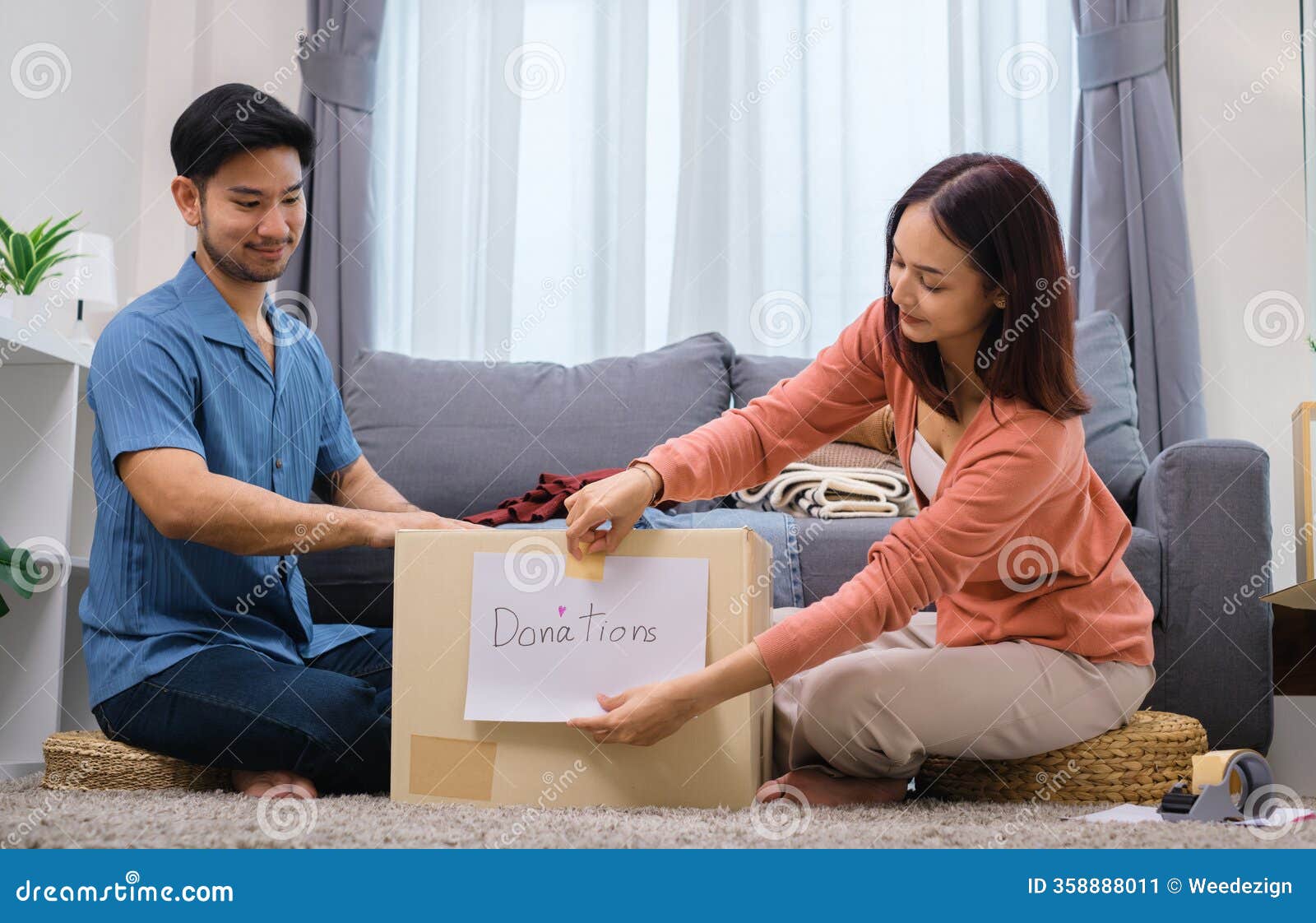 Group of Friend Sorting and Packing Clothes into a Donation Box.community Support, and ...