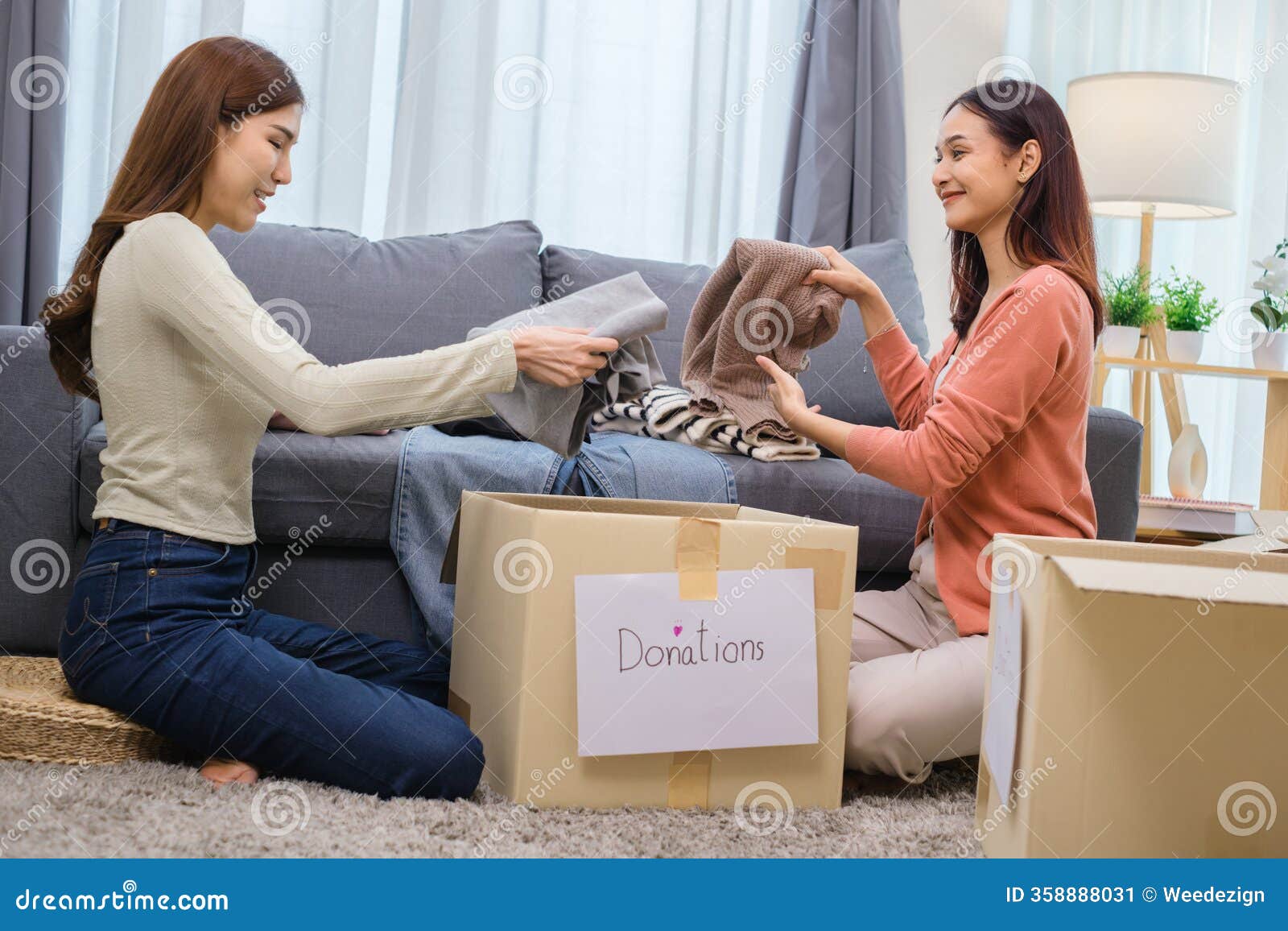 Group of Friend Sorting and Packing Clothes into a Donation Box ...