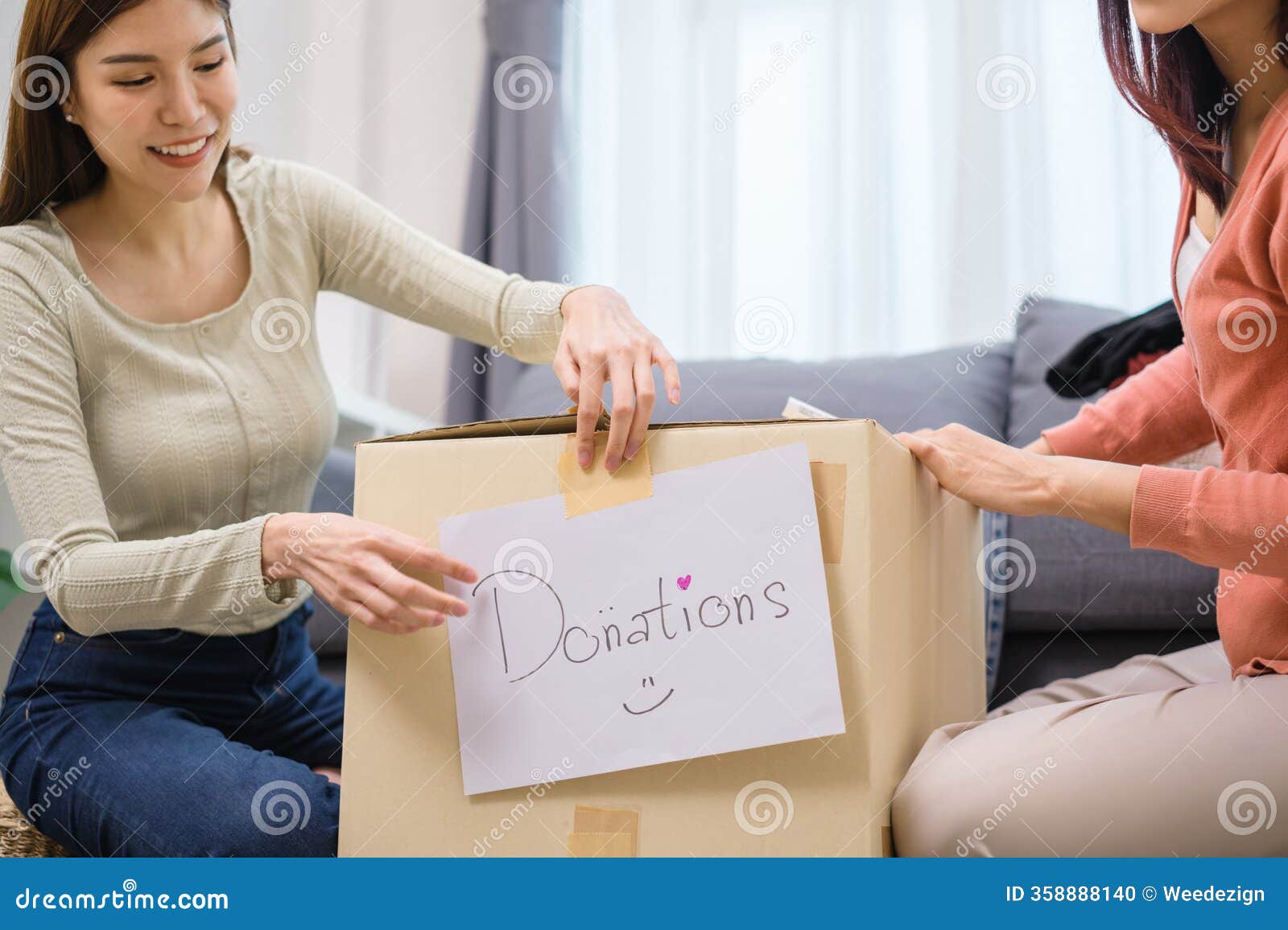 Group of Friend Sorting and Packing Clothes into a Donation Box ...