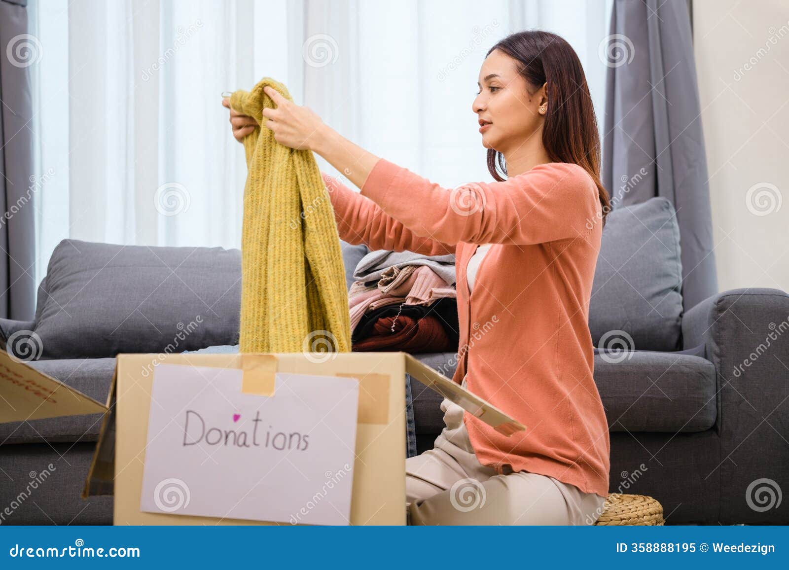 Group of Friend Sorting and Packing Clothes into a Donation Box ...