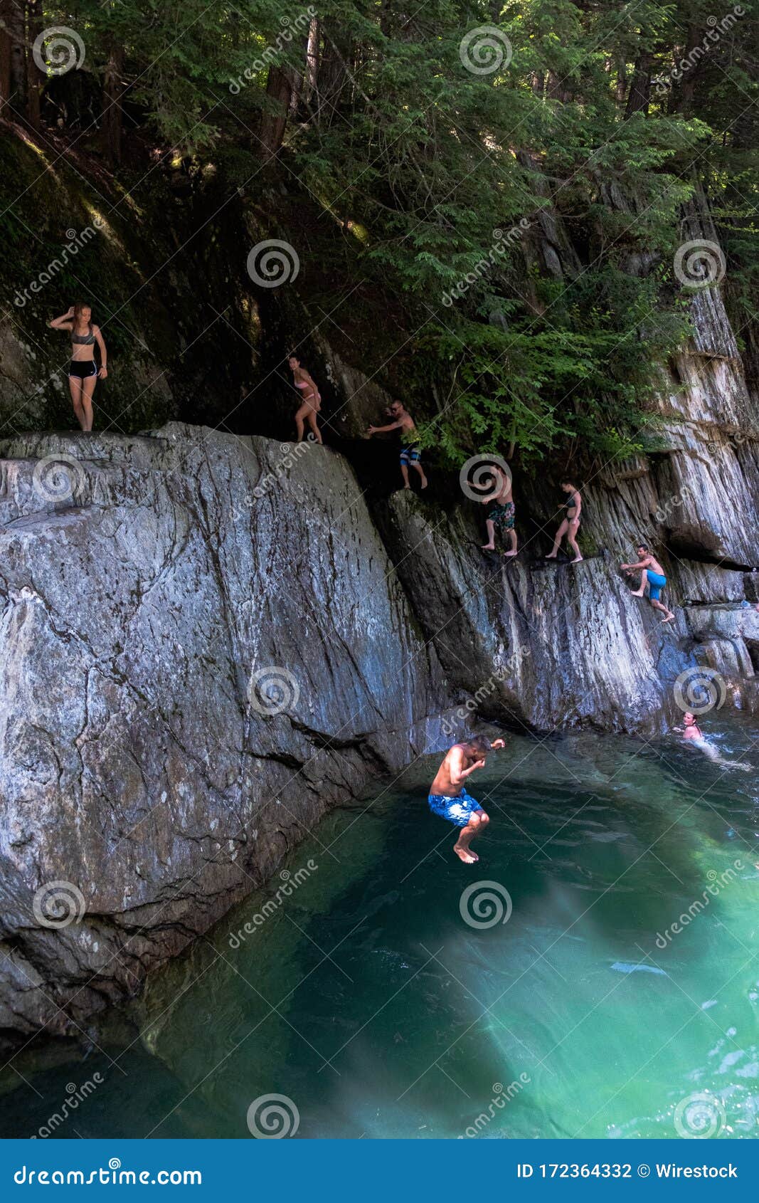Group of Friends Climbing a Diving Cliff of a Beautiful Lagoon ...