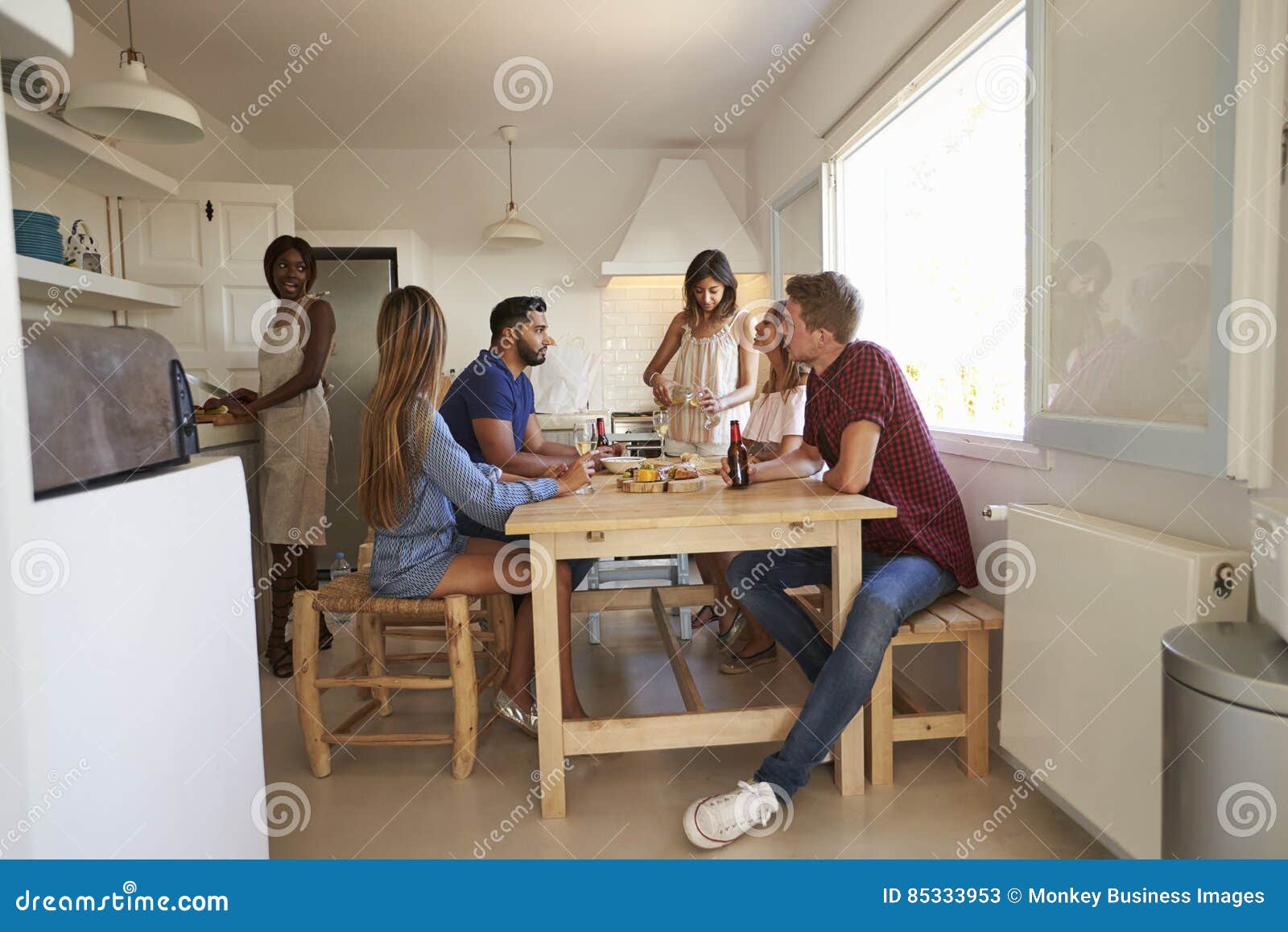 Group of Friends at Dinner Party, One of Them Preparing Food Stock ...