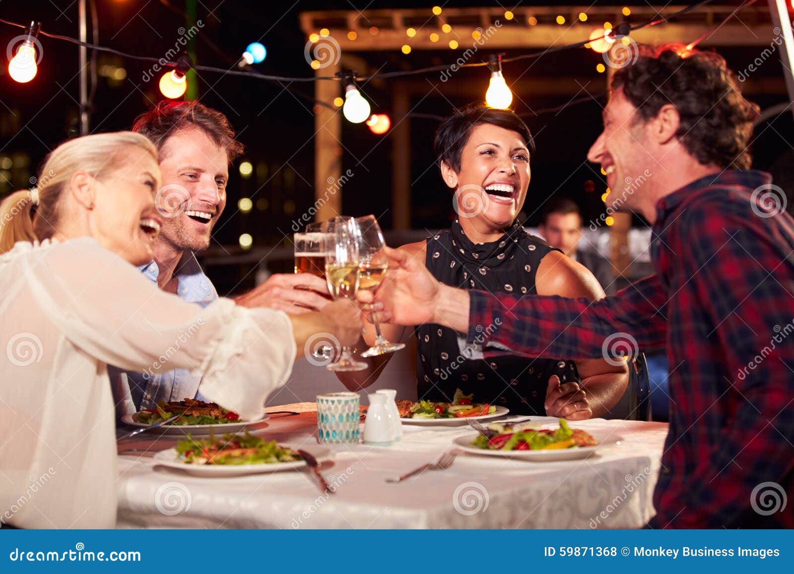 Group Of Friends Eating Dinner At Rooftop Restaurant Stock Photo ...