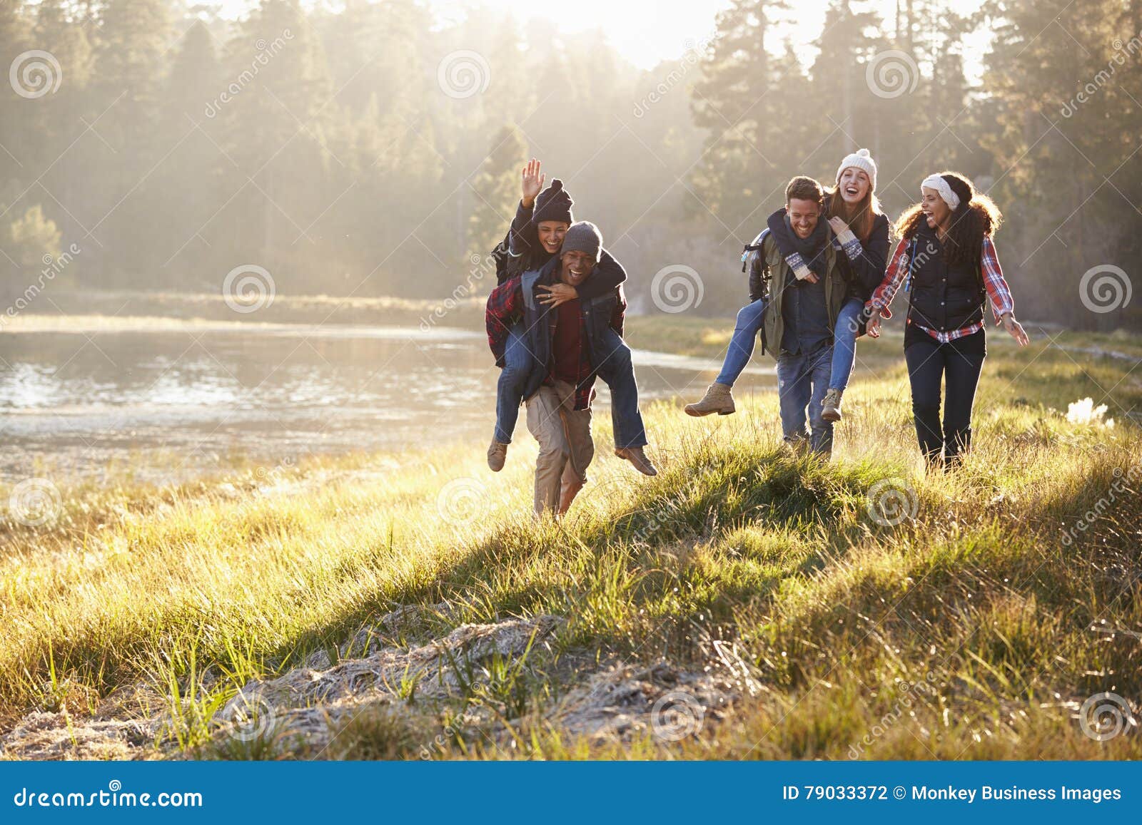 Group of Friends Have Fun Piggybacking by a Lake Stock Photo - Image of ...