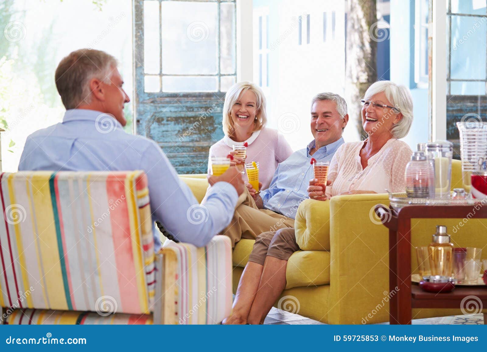 Group of Friends at Home Relaxing in Lounge with Cold Drinks Stock ...