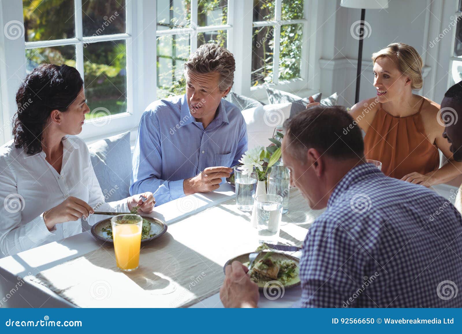 Group of Friends Interacting while Having Meal Stock Photo - Image of ...
