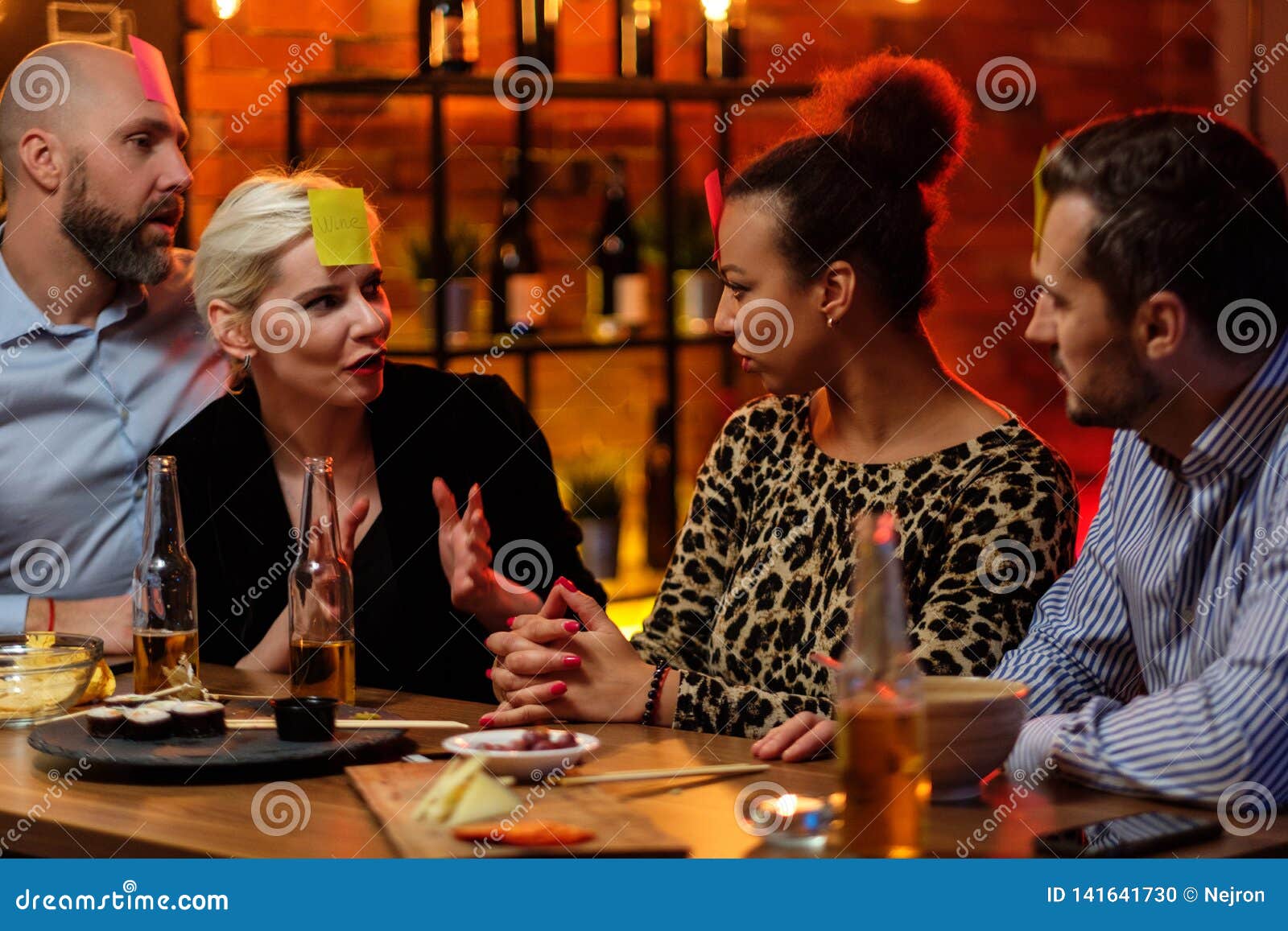 Group of Friends Playing Sticky Head Game Behind Bar Counter in a Cafe ...