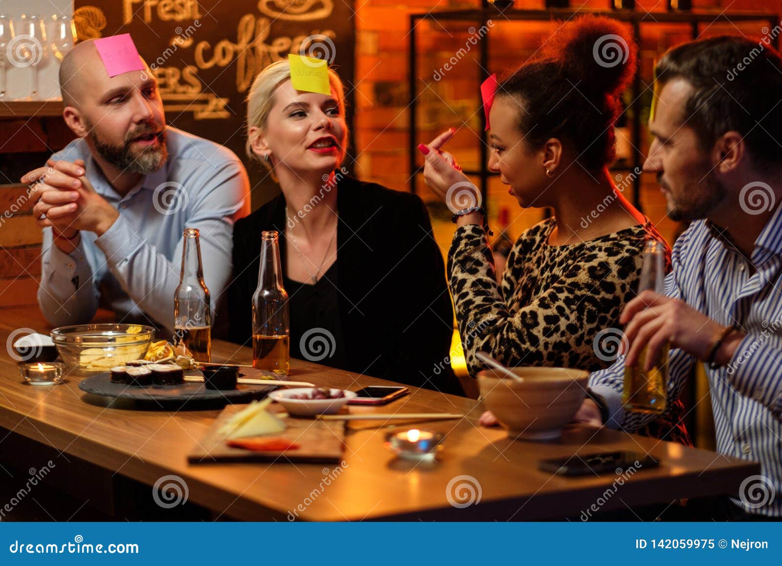 Group of Friends Playing Sticky Head Game Behind Bar Counter in a Cafe ...