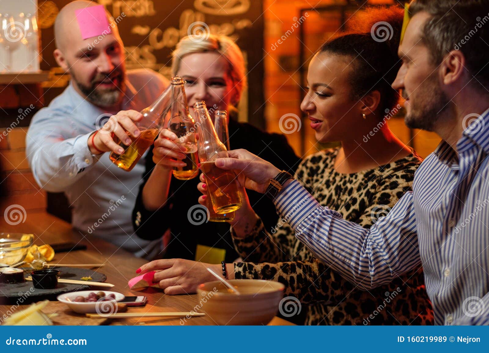 Group of Friends Playing Sticky Head Game Behind Bar Counter in a Cafe ...