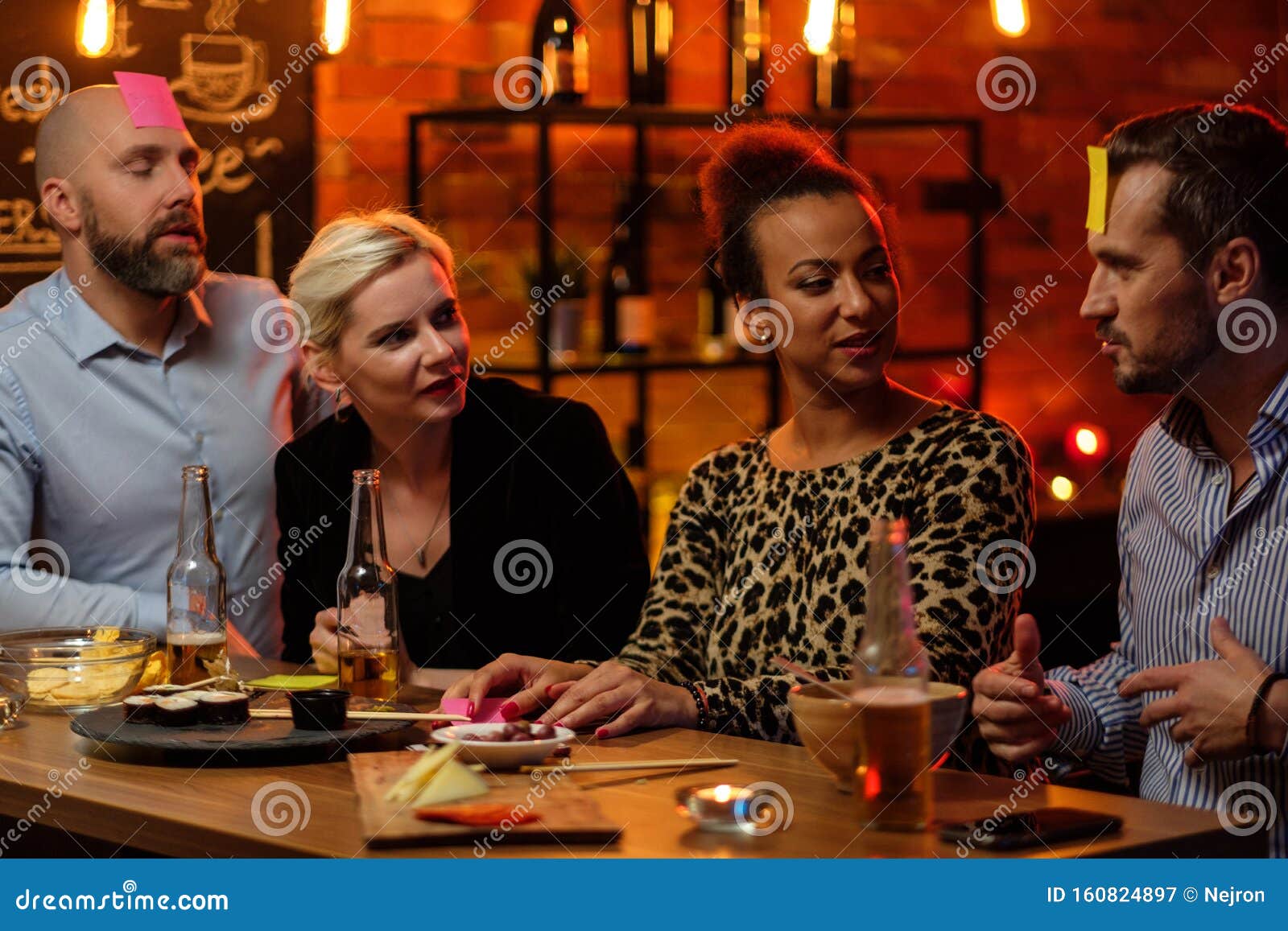 Group of Friends Playing Sticky Head Game Behind Bar Counter in a Cafe ...