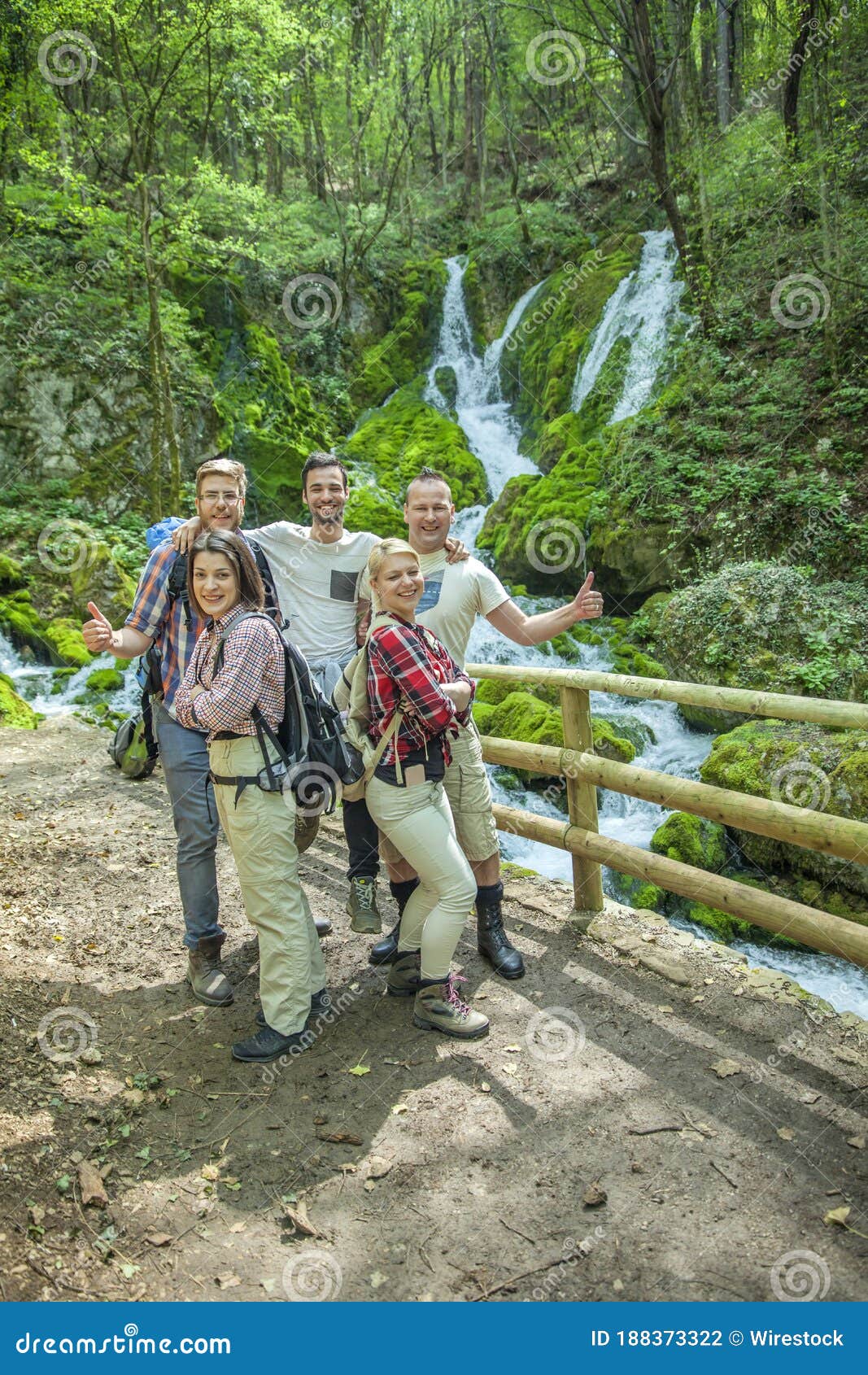 Group of Friends Posing in Front of a Beautiful Waterfall on a Sunny ...