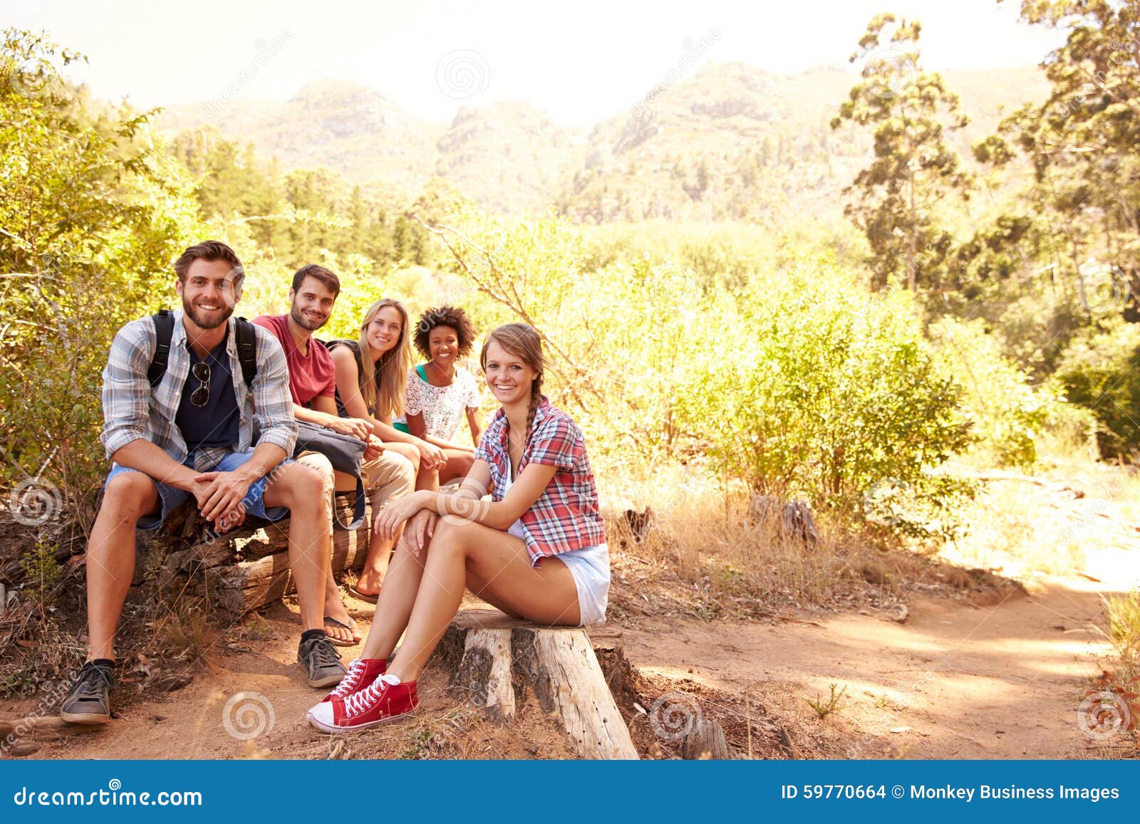 Group of Friends Resting on Walk through Countryside Stock Photo ...