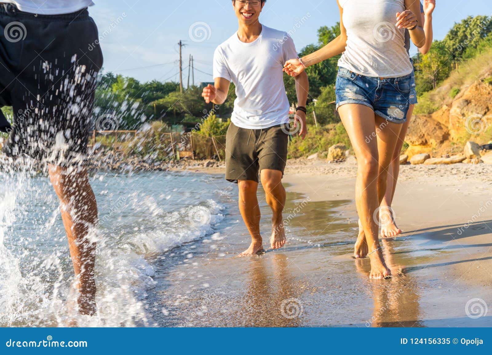 Group of Friends Run through Waves Together on Beach Vacation. Stock ...