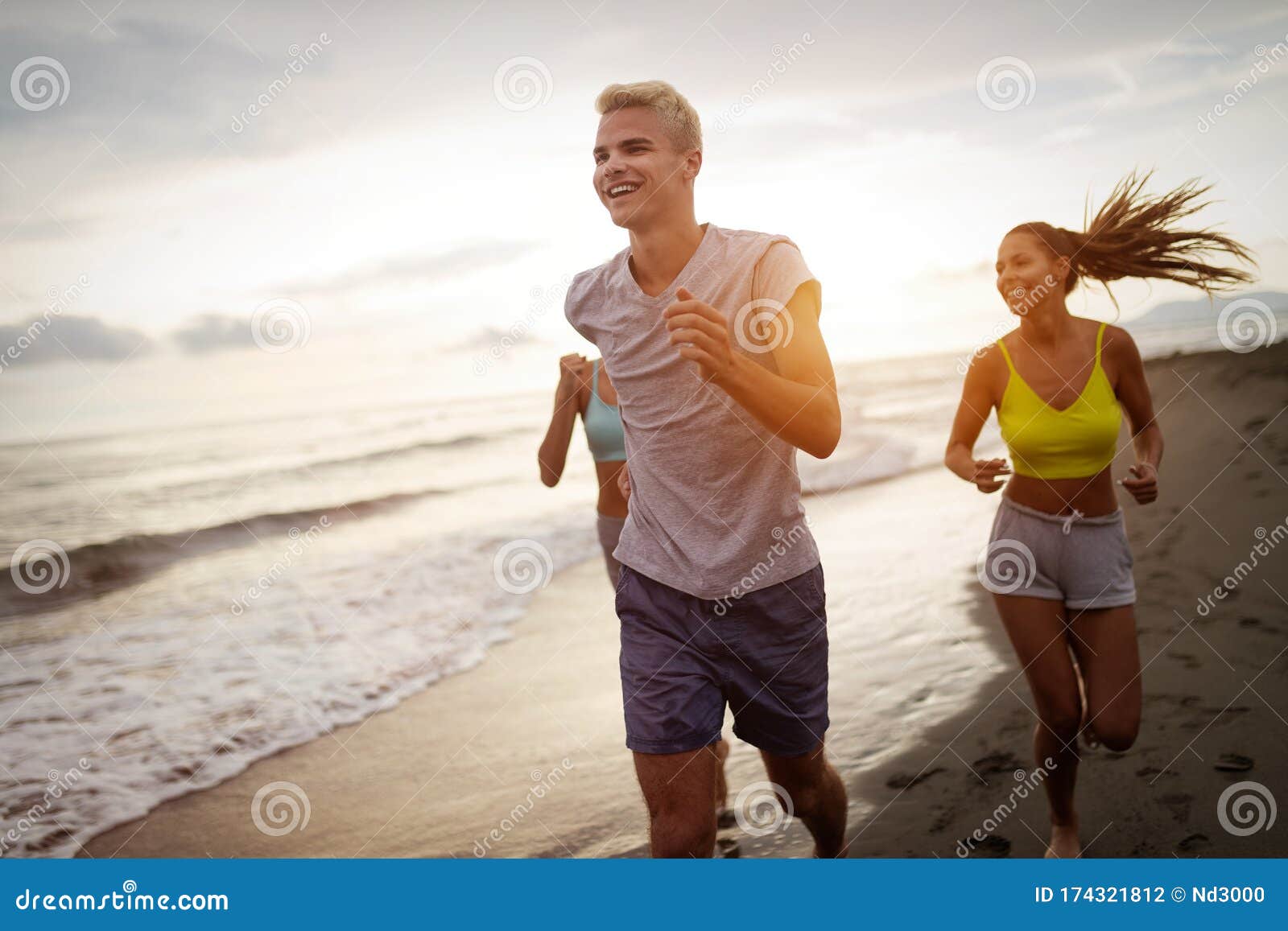Group of Friends Running at the Beach on Beautiful Summer Sunset Stock ...