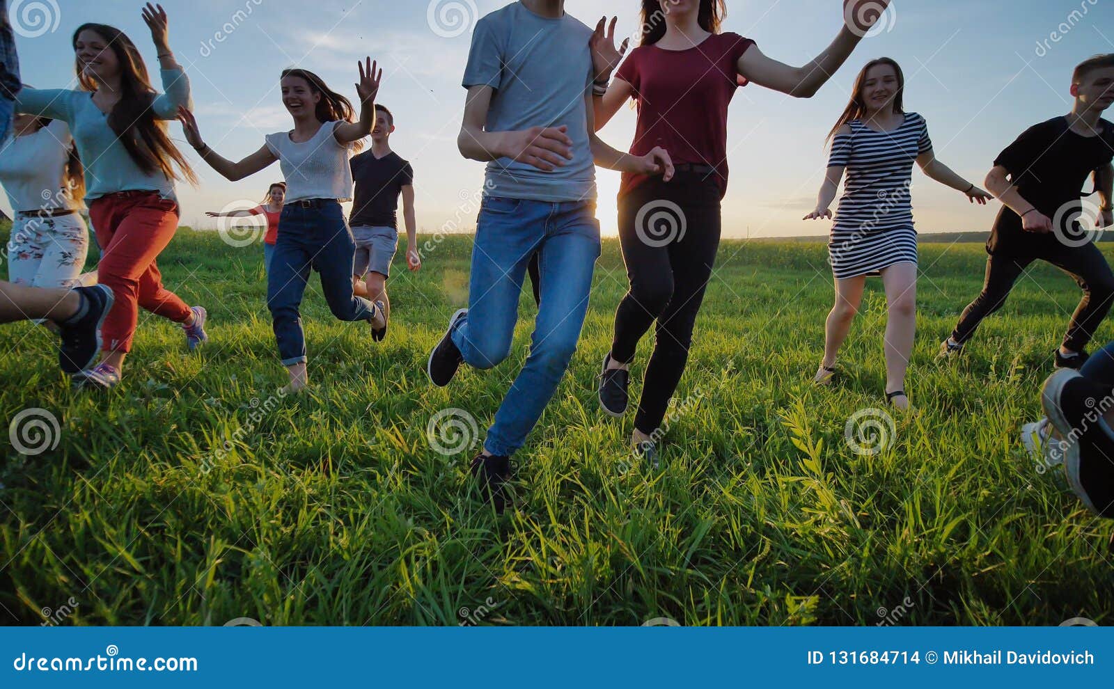 Group of Friends Running Happily Together in the Grass Stock Photo ...