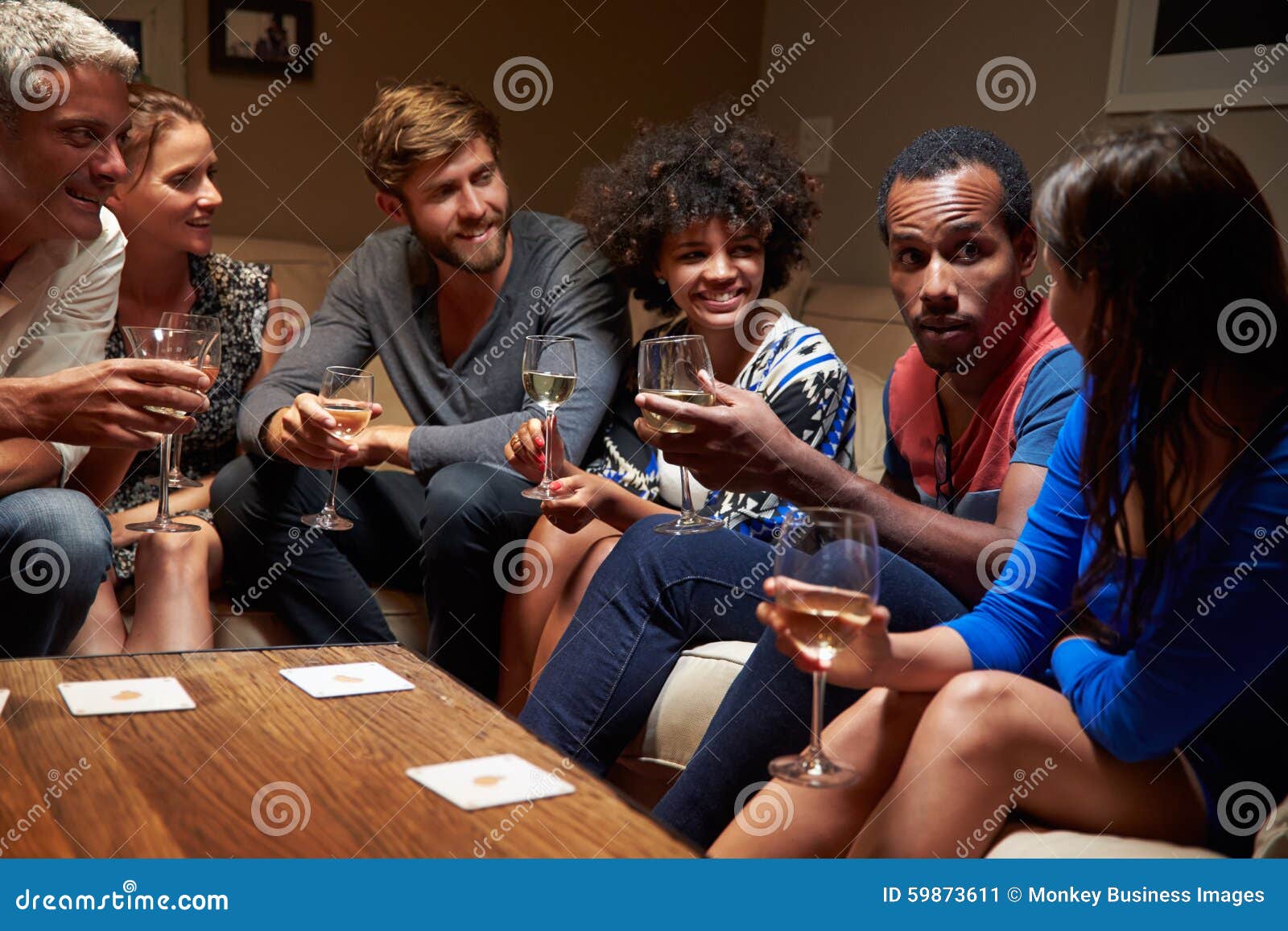 Group of Friends Sitting Around a Table at House Party Stock Image ...