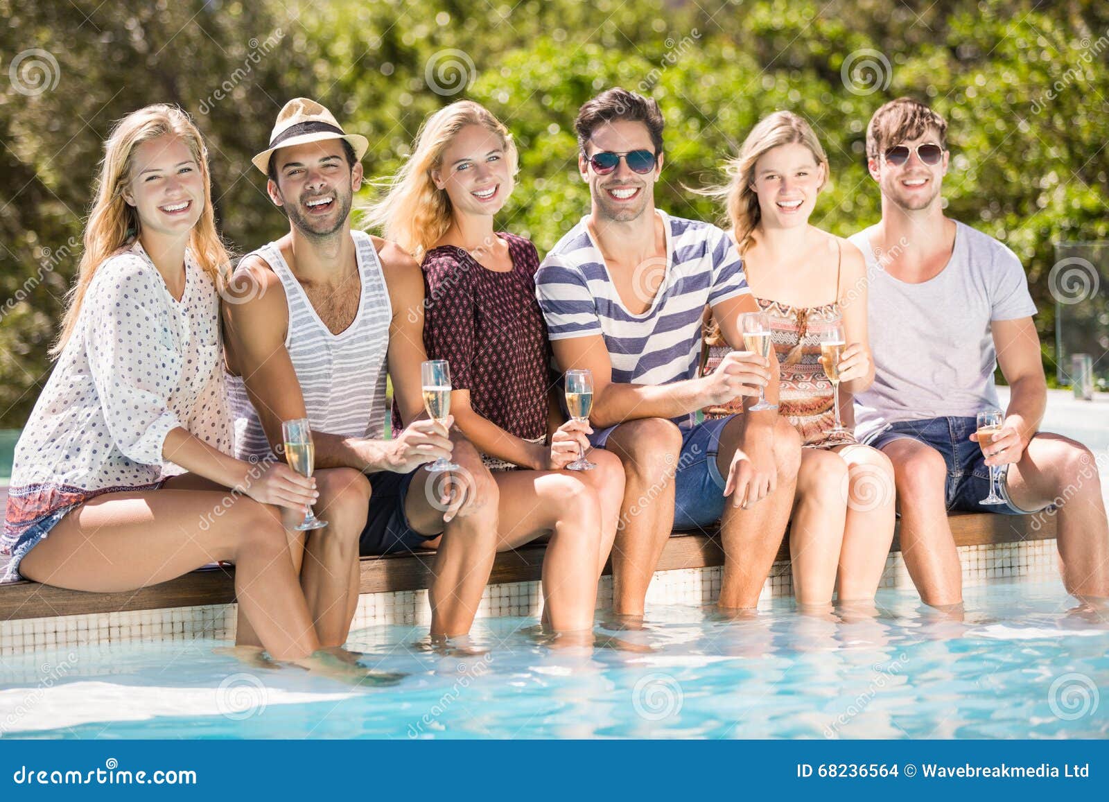 Group of Friends Sitting at Poolside with Glass of Champagne Stock ...
