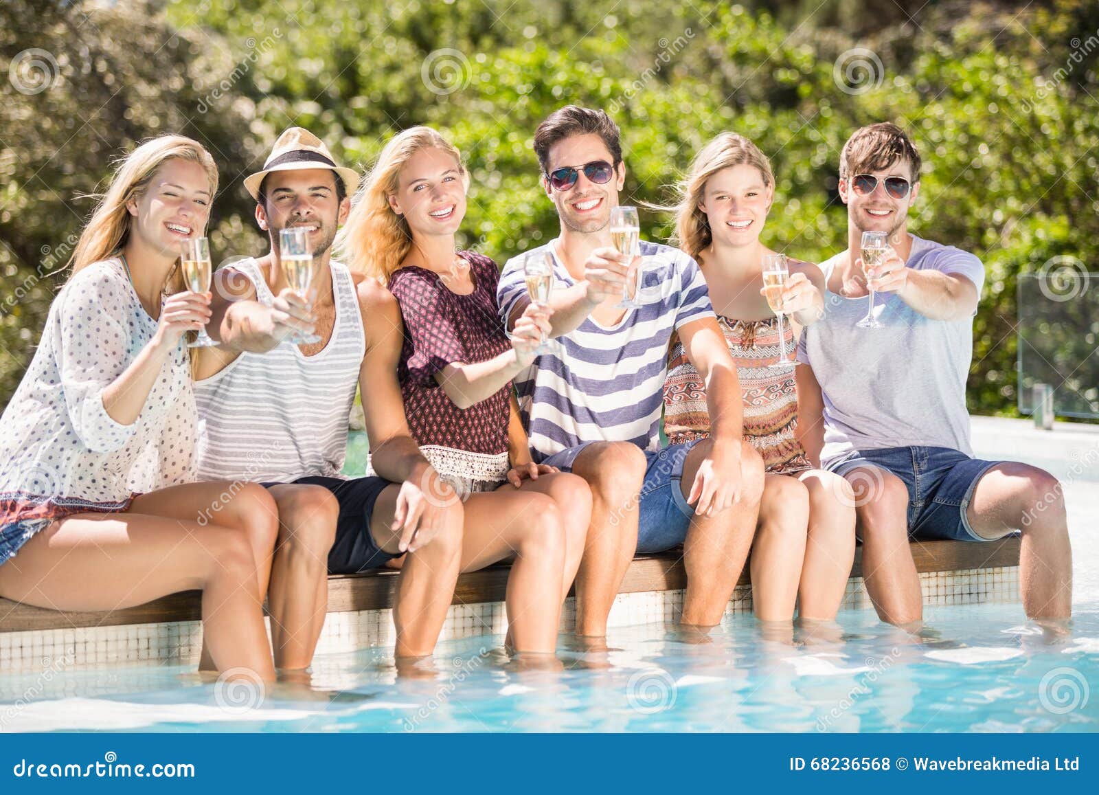 Group of Friends Sitting at Poolside with Glass of Champagne Stock ...