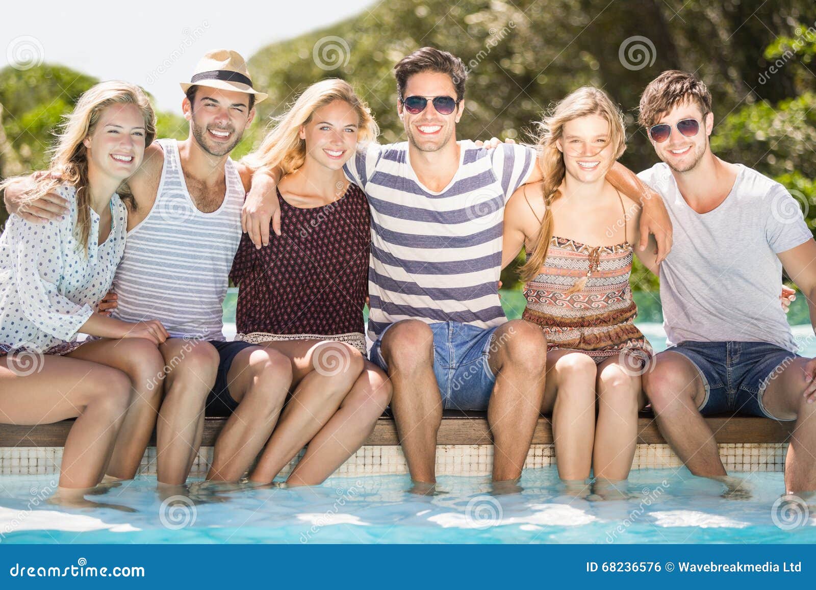 Group of Friends Sitting Side by Side at Poolside Stock Photo - Image ...