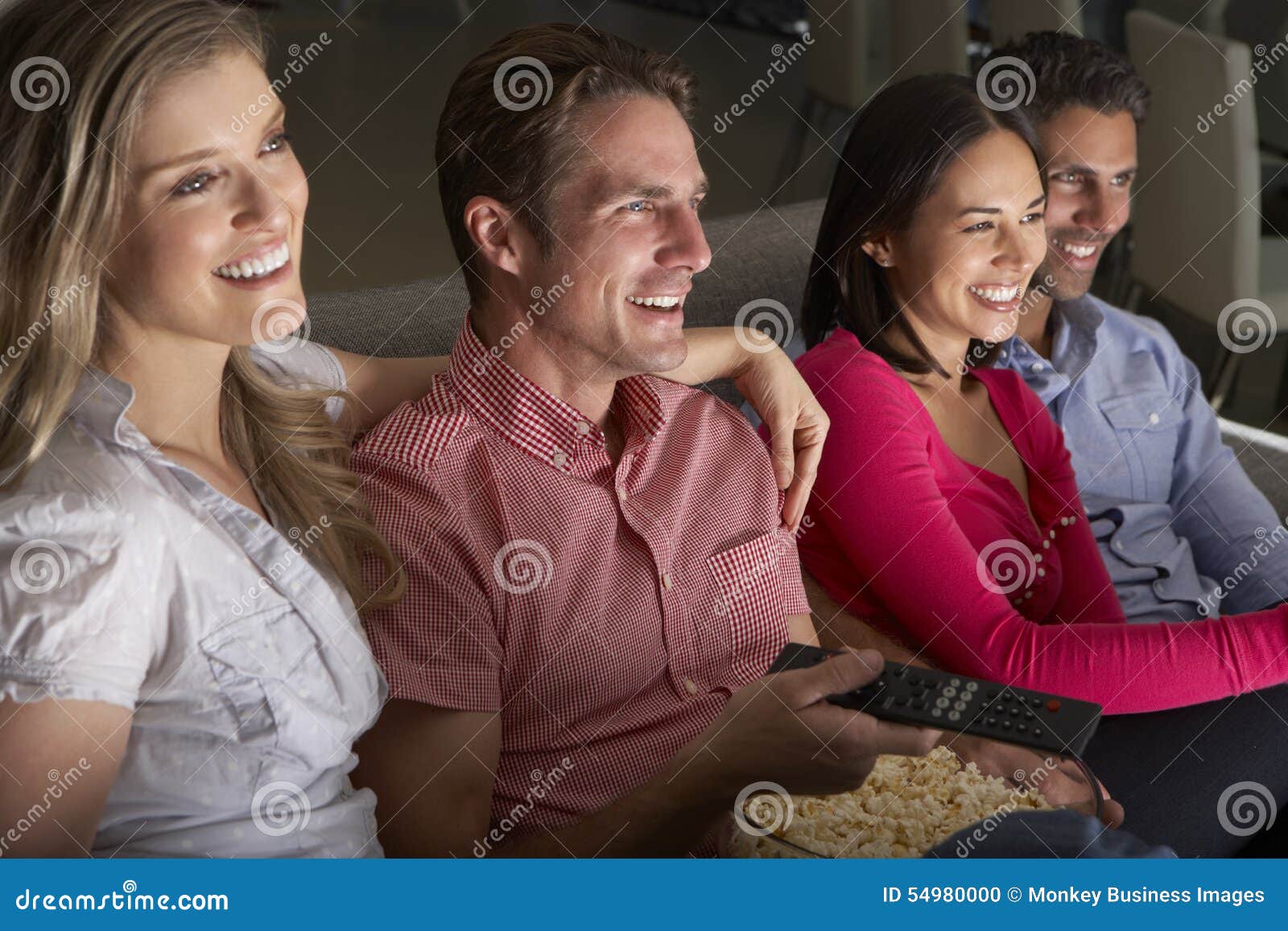 Group of Friends Sitting on Sofa Watching TV Together Stock Photo ...