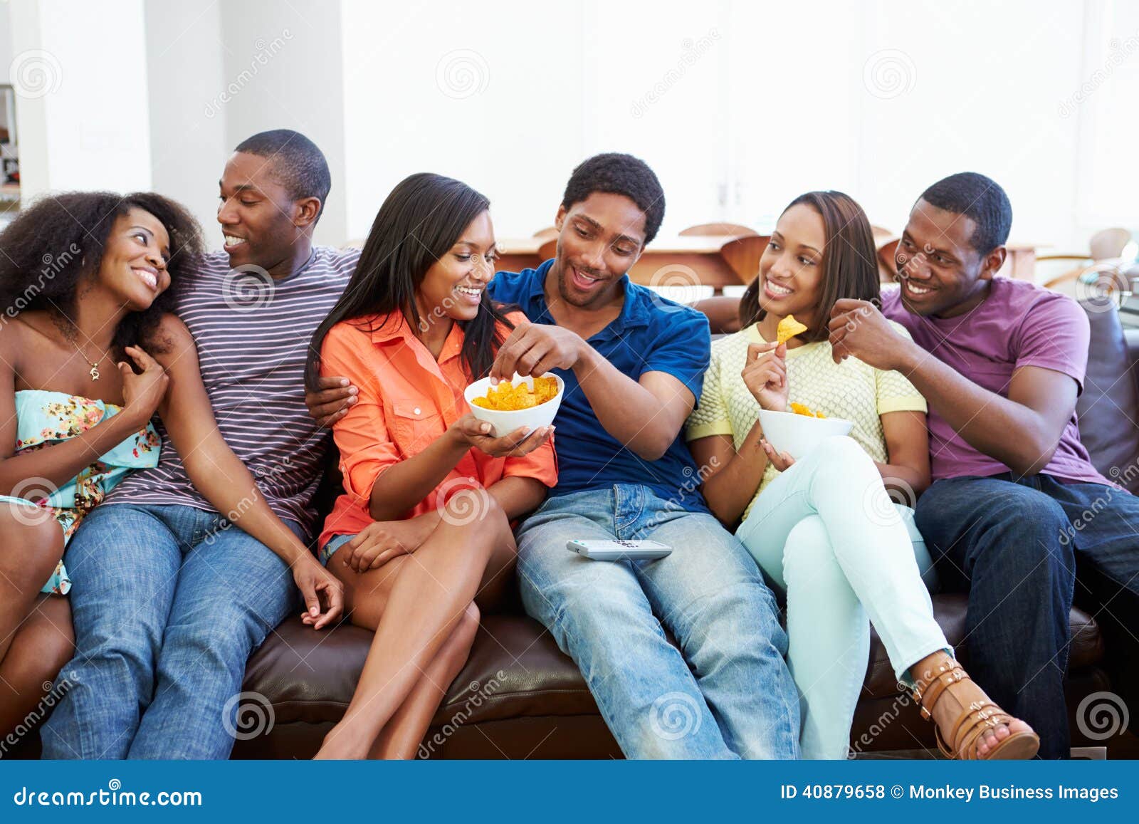 Group of Friends Sitting on Sofa Watching TV Together Stock Photo ...