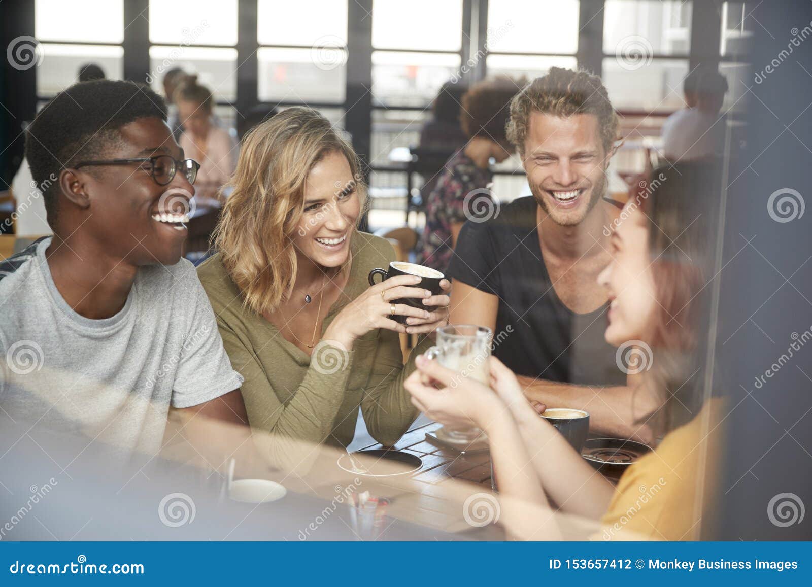 Group of Friends Sitting at Table in Busy Coffee Shop Talking Stock ...