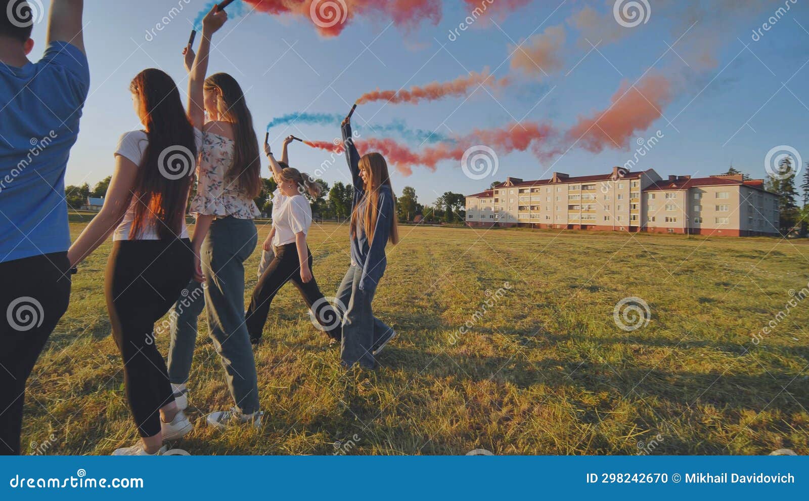 A Group of Friends Spraying Multi-colored Smoke at Sunset. Stock Photo ...