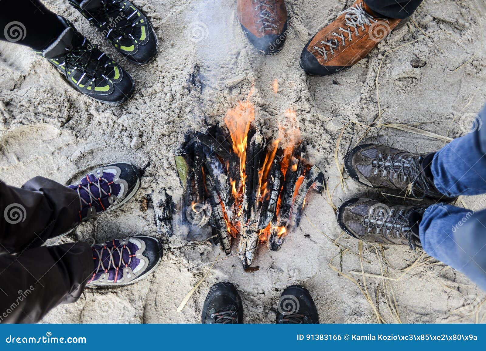 A Group of Friends Standing Around a Fire on a Beach Stock Photo ...