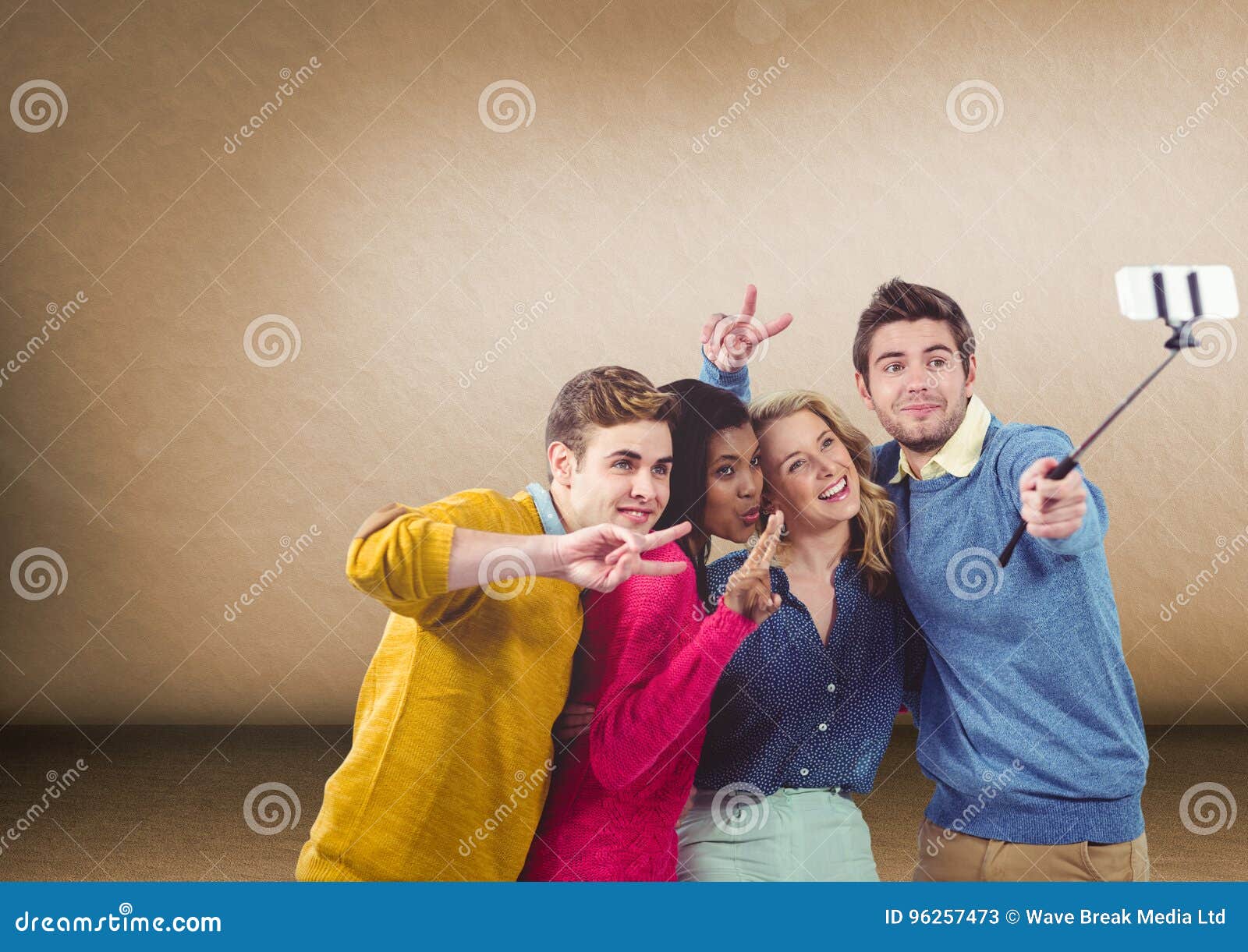 Group of Friends Taking Selfie in Front of Blank Brown Background Stock ...