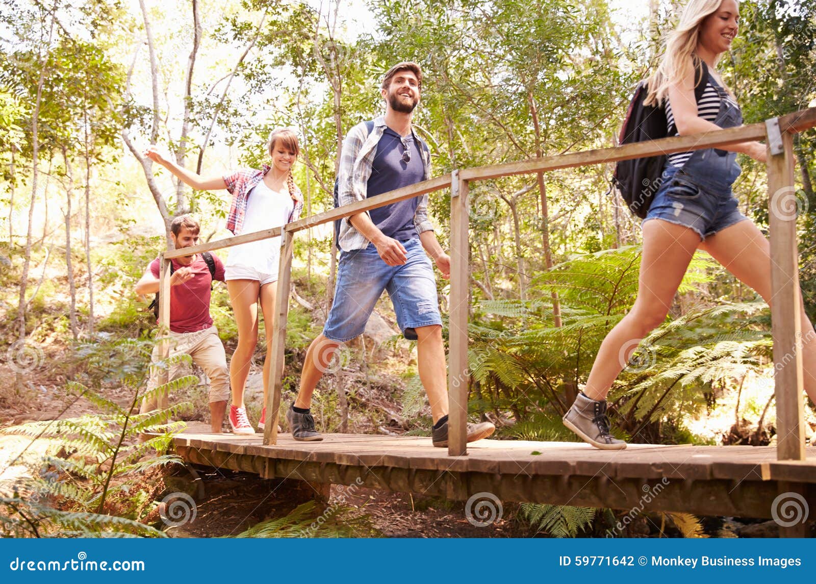 Group of Friends on Walk Crossing Wooden Bridge in Forest Stock Photo ...