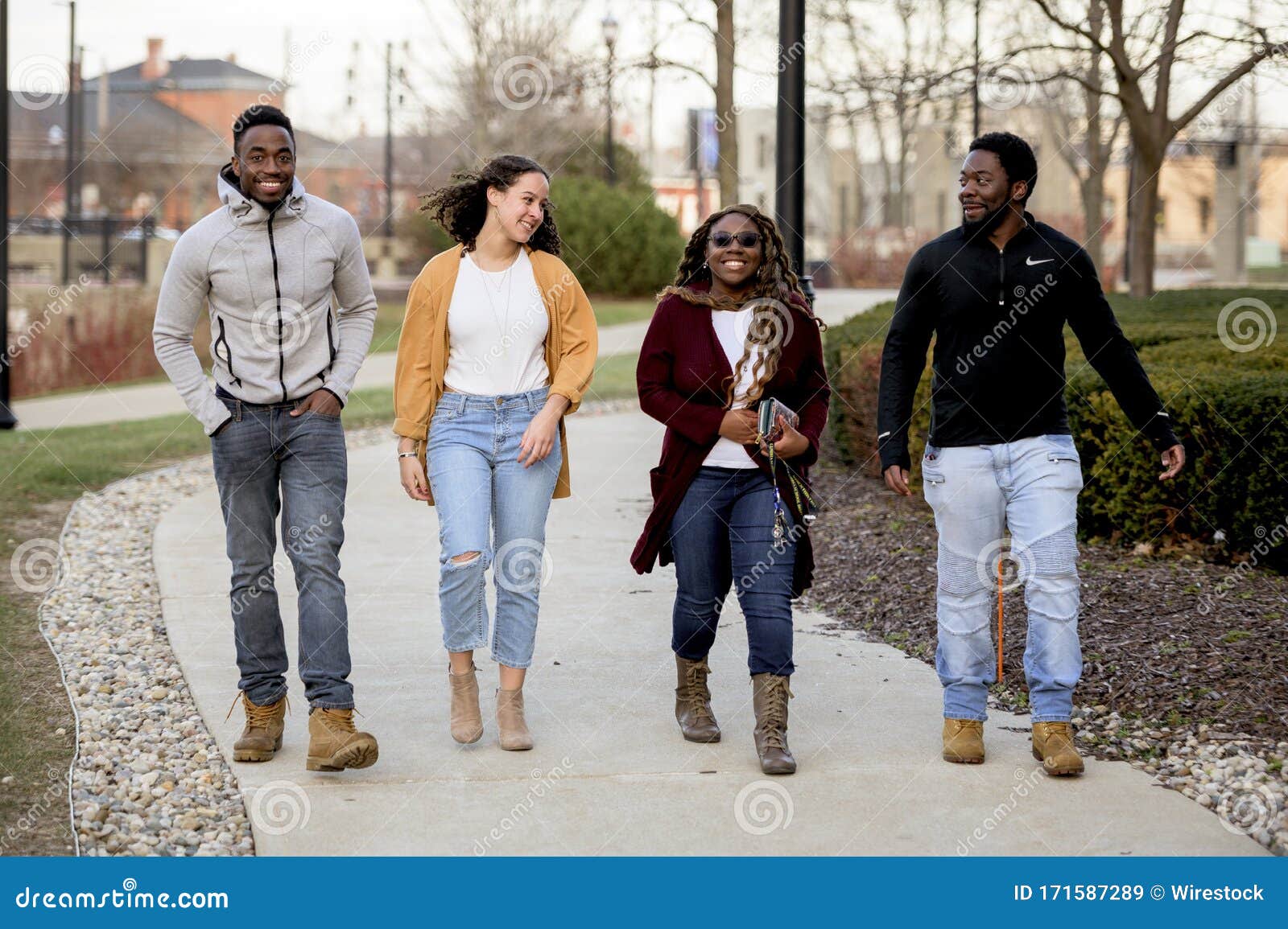 Group of Friends Walking Happily on the Sidewalk in a Park Stock Image ...