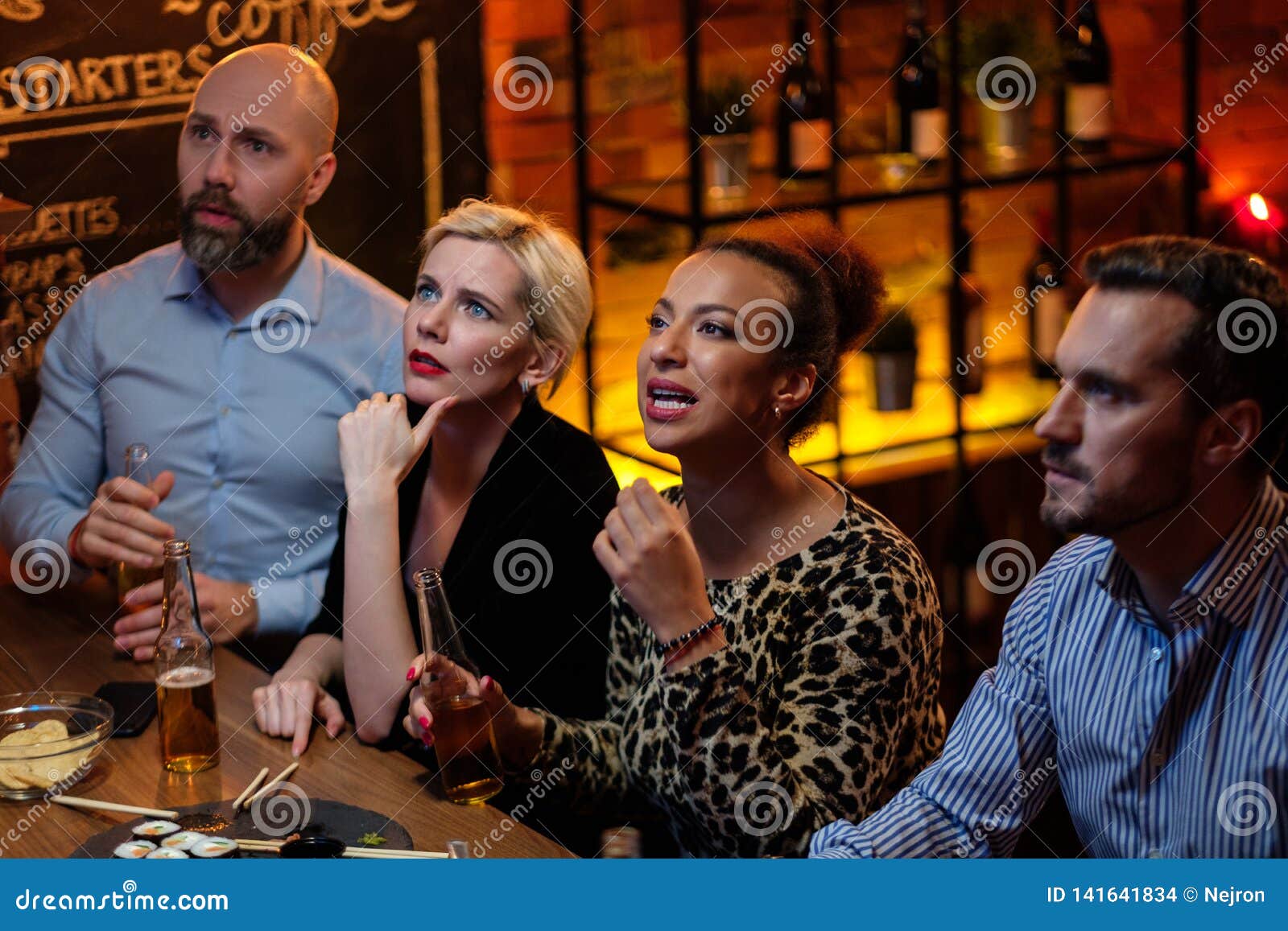 Group of Friends Watching Tv in a Cafe Behind Bar Counter Stock Photo ...