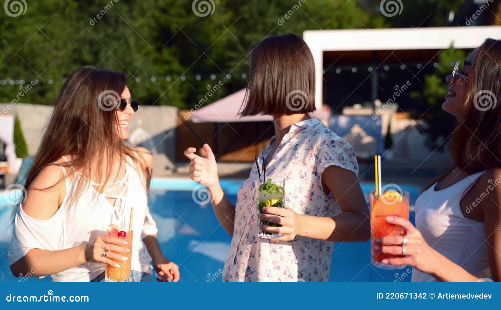 Group Of Girls Having Fun At Summer Pool Party Clinking Glasses With Cocktails And Dancing Near