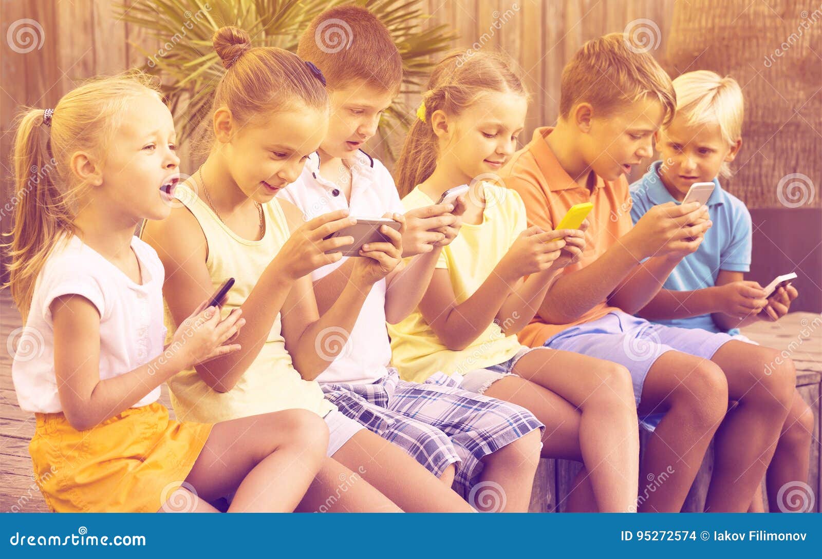 Group of Glad Children Playing with Mobile Phones Outdoors Stock Photo ...