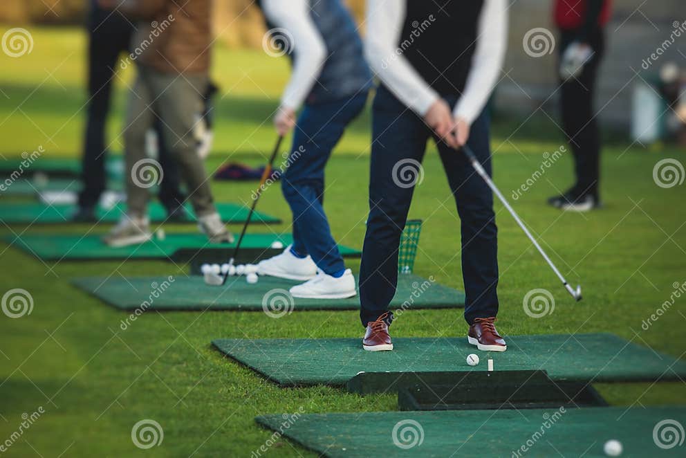 Group of Golfers Practicing and Training Golf Swing on Driving Range ...