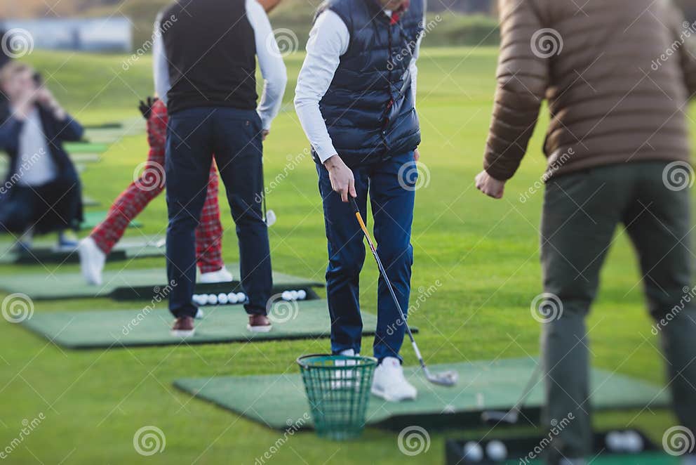 Group of Golfers Practicing and Training Golf Swing on Driving Range ...