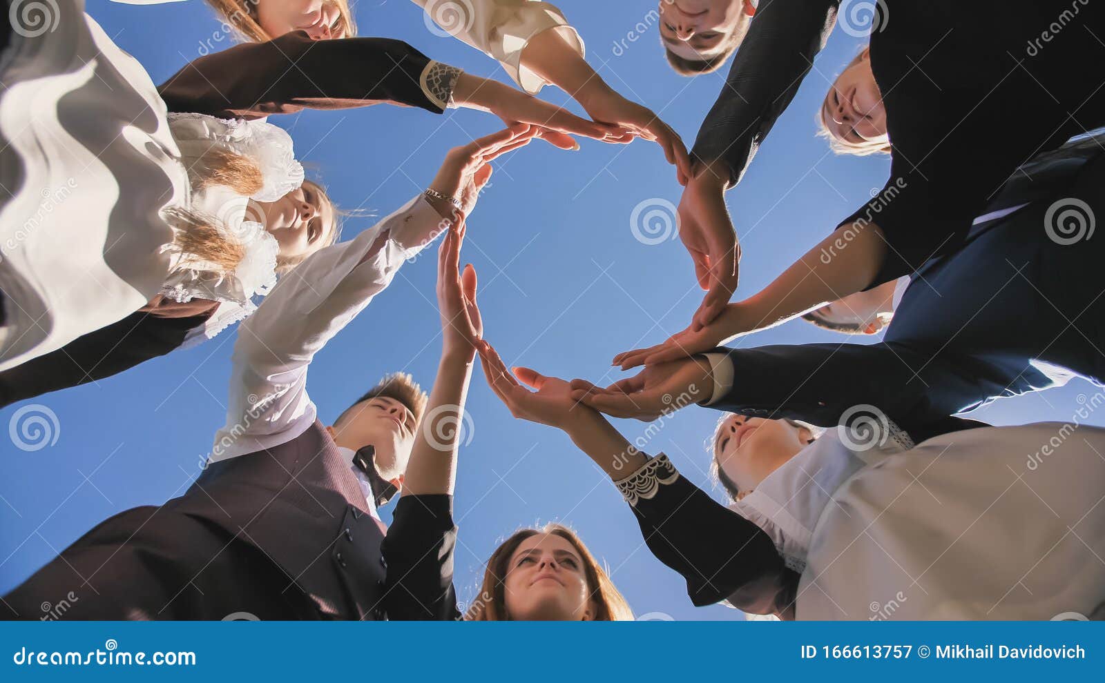A Group of Graduate Students Make a Circle from the Palms of Their ...