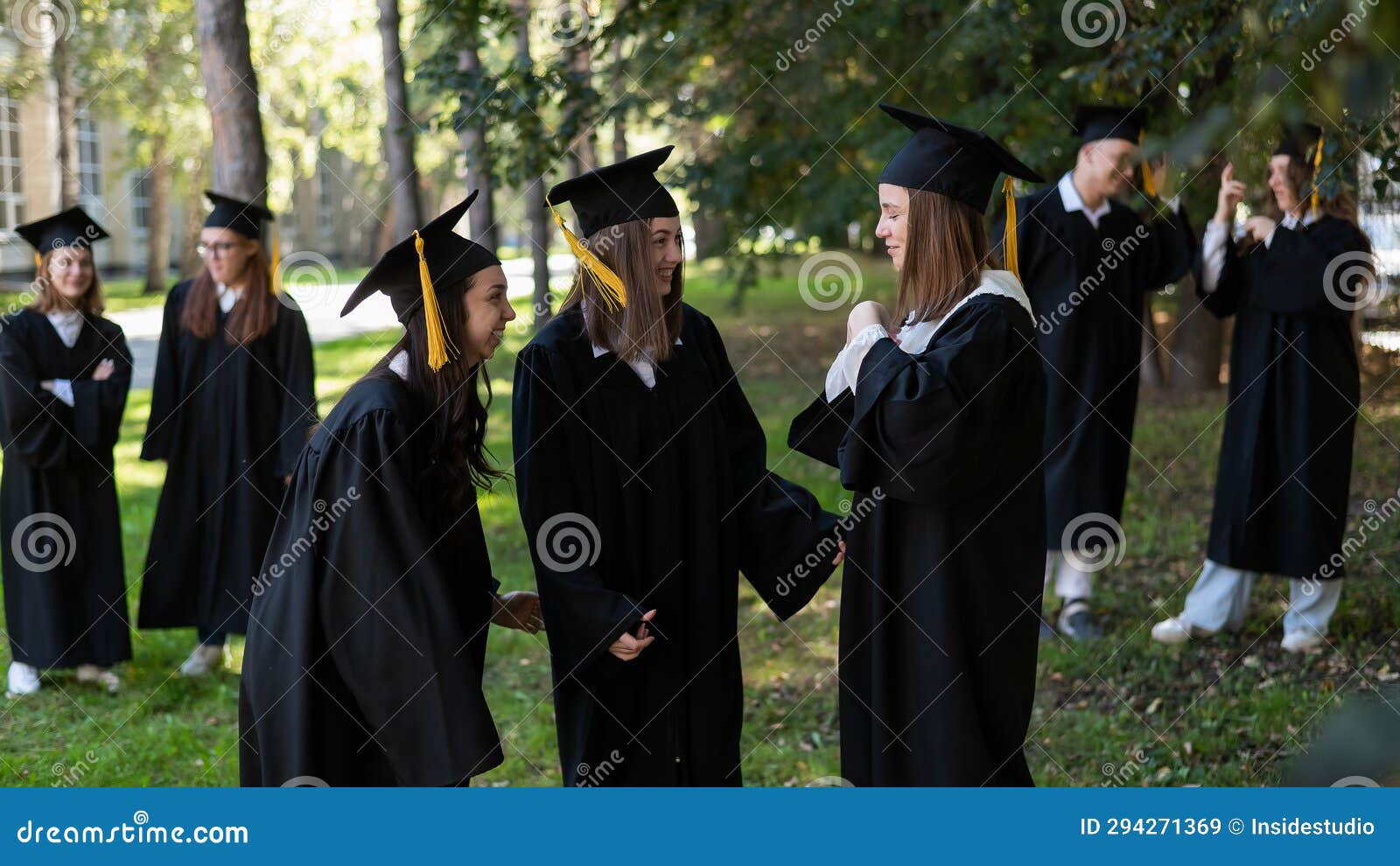 A Group of Graduates in Robes Congratulate Each Other on Their ...