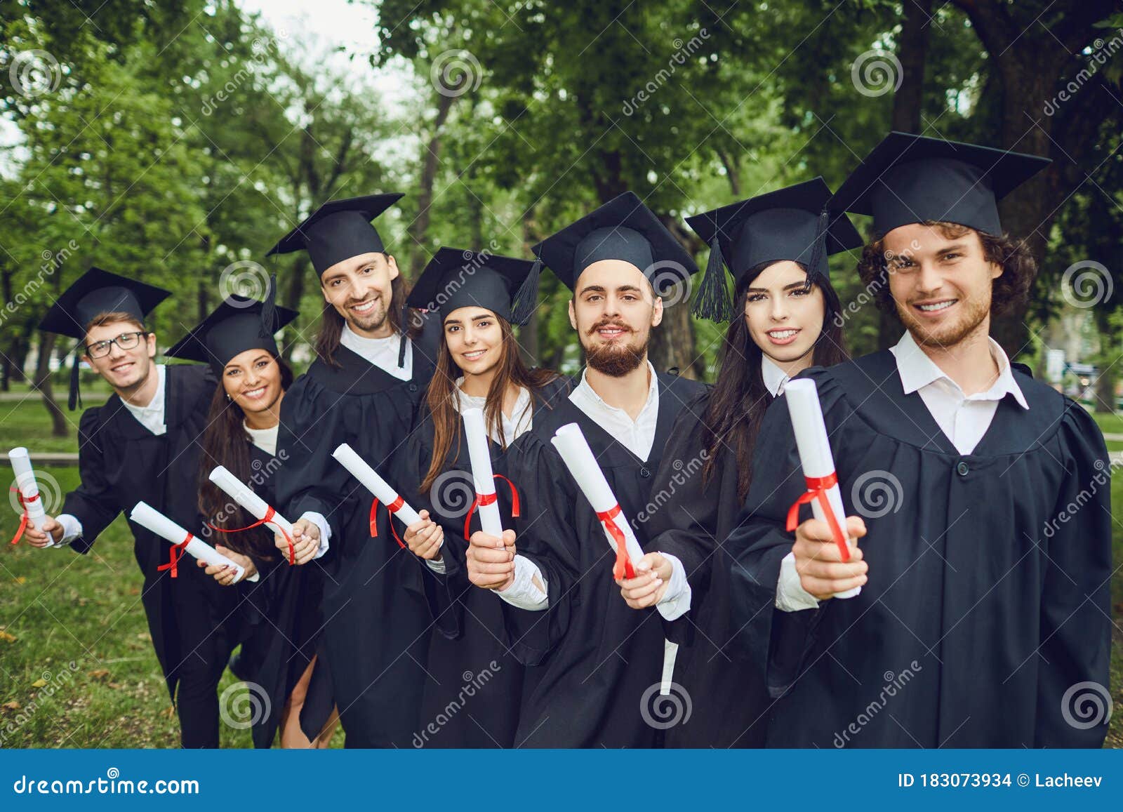 A Group of Graduates Smiling Stock Photo - Image of gown, graduate ...