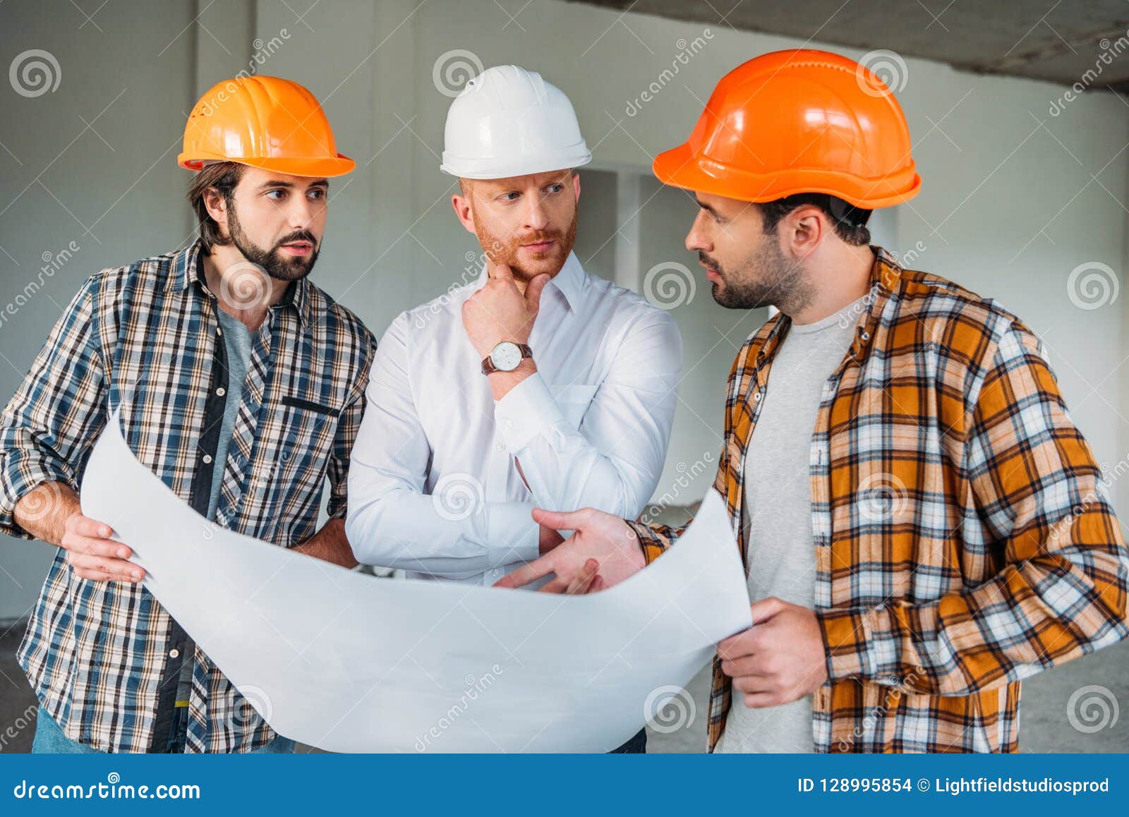 Group of Handsome Architects with Blueprint Having Conversation Inside ...