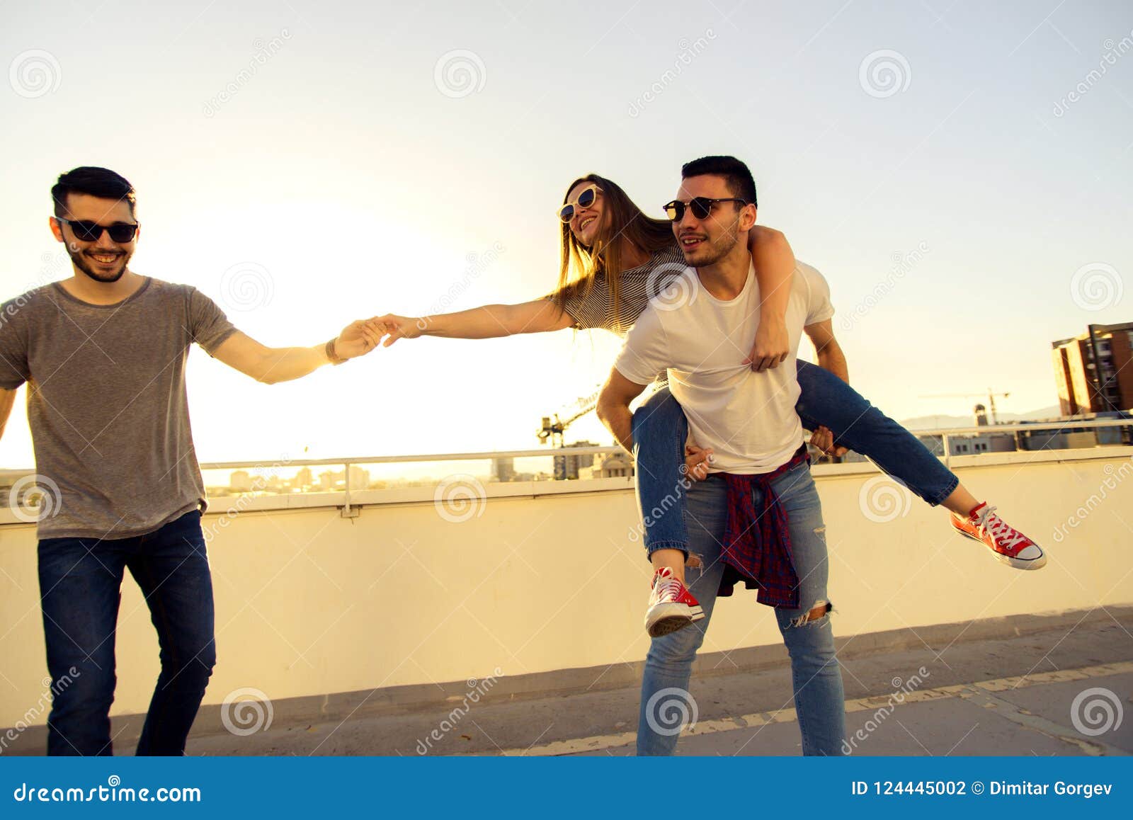 Three Young People Having Fun at a Rooftop on Sunset Stock Photo ...