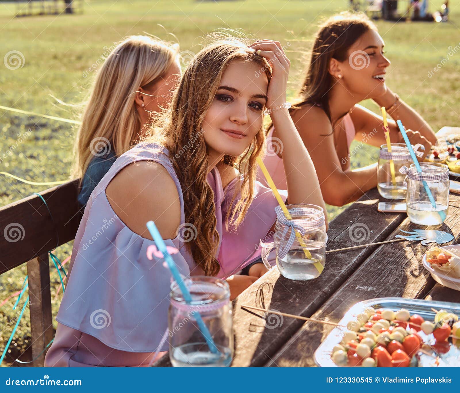 Group Of Happy Girlfriends Sitting At The Table Together Celebrating A
