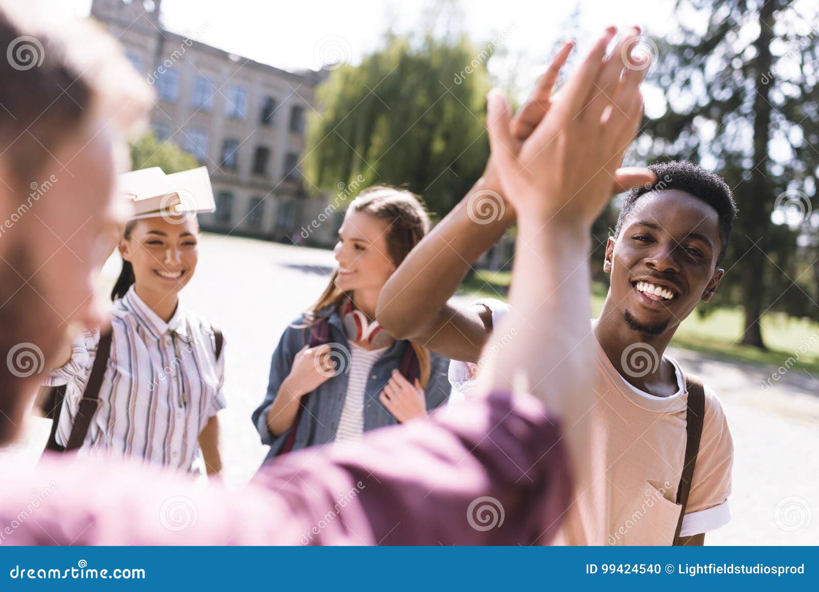 Students giving highfive stock photo. Image of group - 99424540