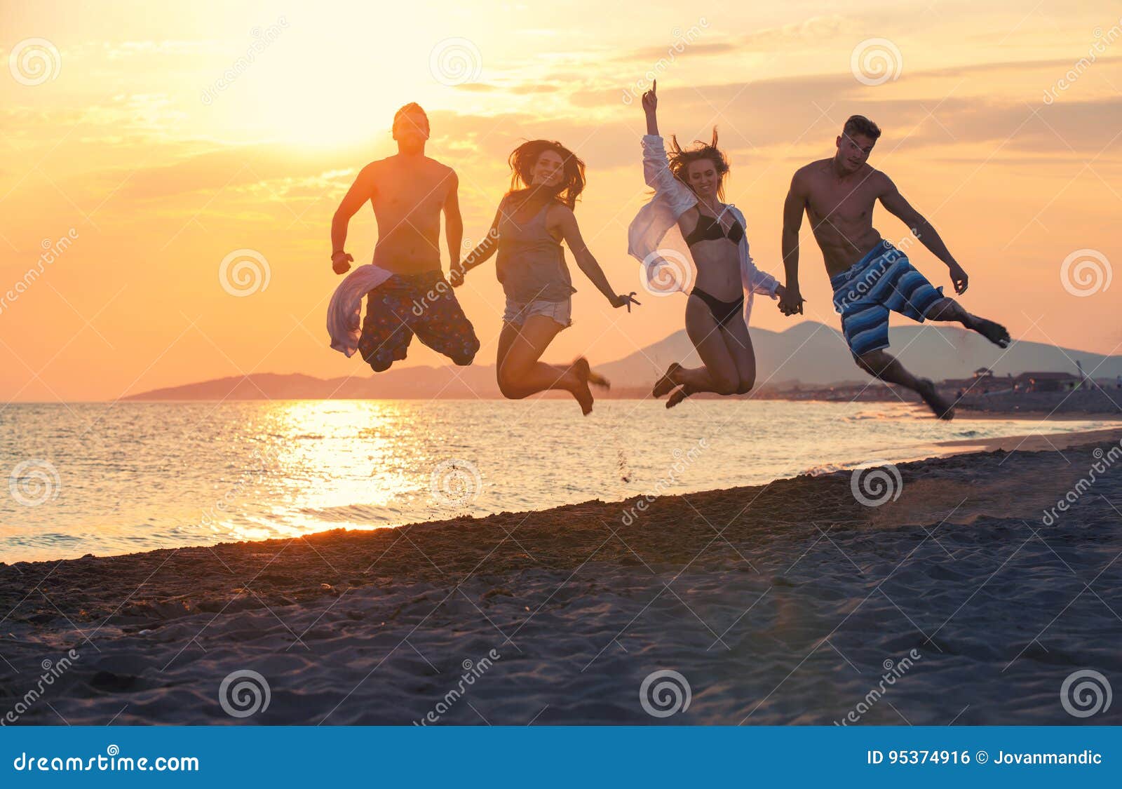 Group of Happy People Dancing and Jumping Inside Sea on Sunset Stock ...