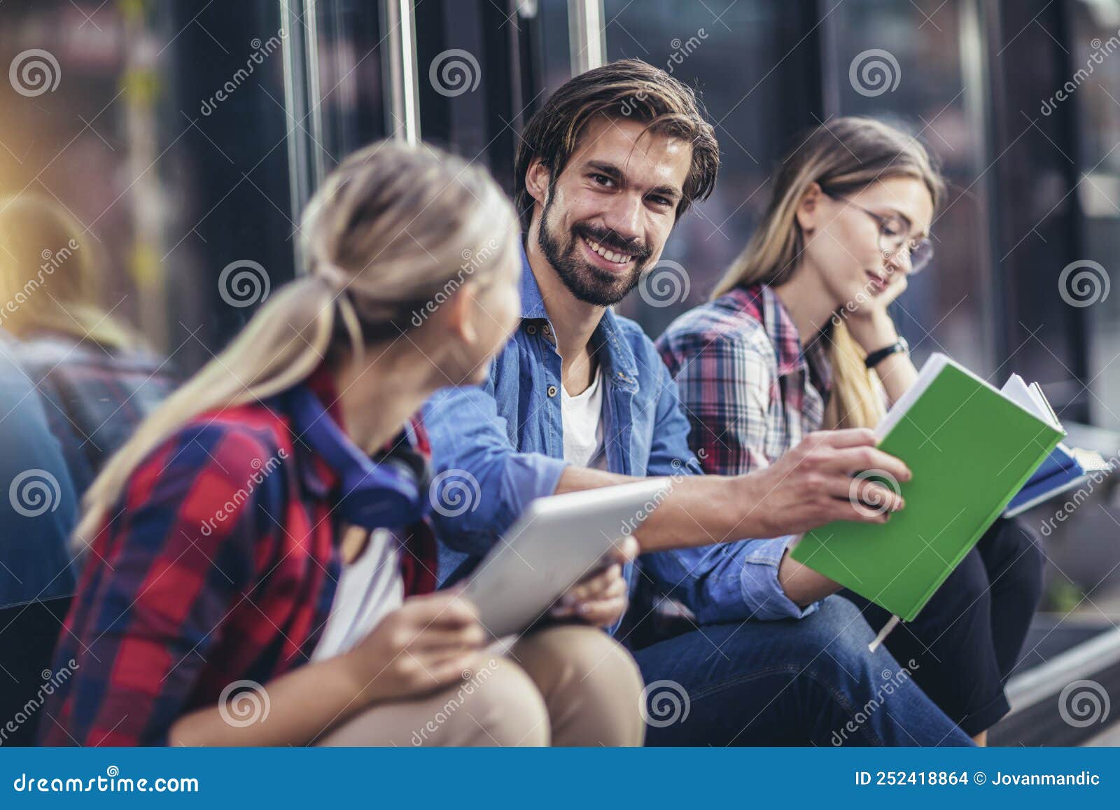 Happy University Students Talking while Sitting Outdoors at Campus ...