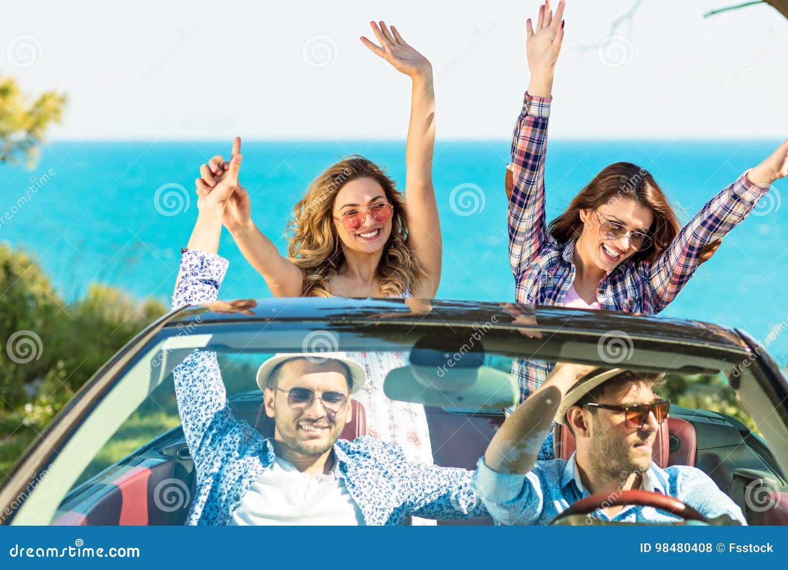 Group of Happy Young Friends in Cabriolet with Raised Hands Driving on ...