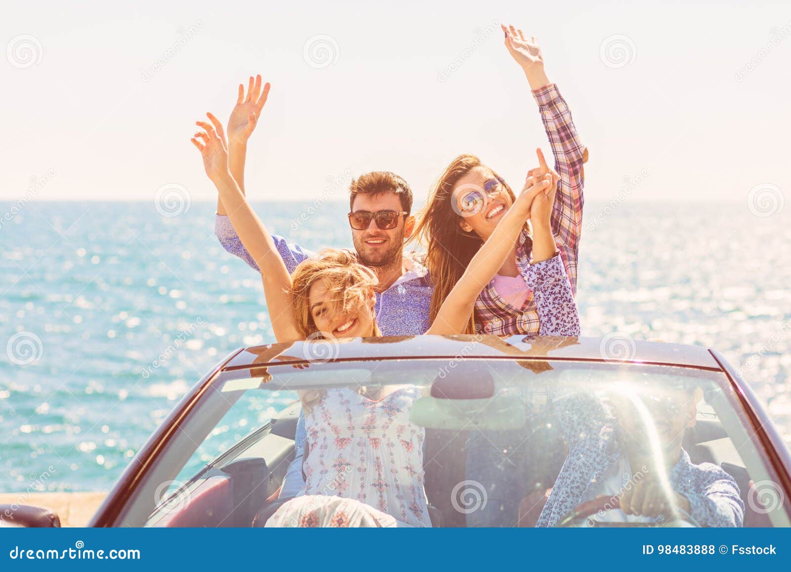 Group of Happy Young Friends in Cabriolet with Raised Hands Driving on ...