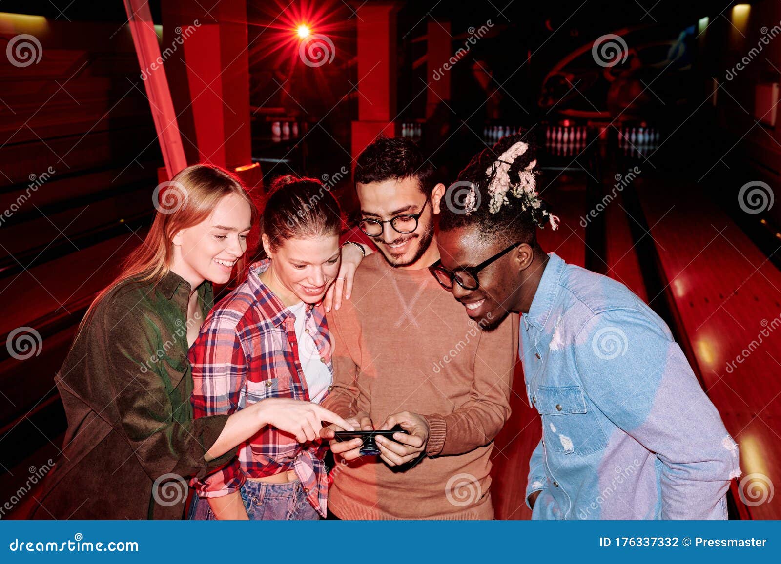 Group of Happy Young Intercultural Friends Scrolling through Their ... Group of Happy Young Intercultural Friends Scrolling through Their ...