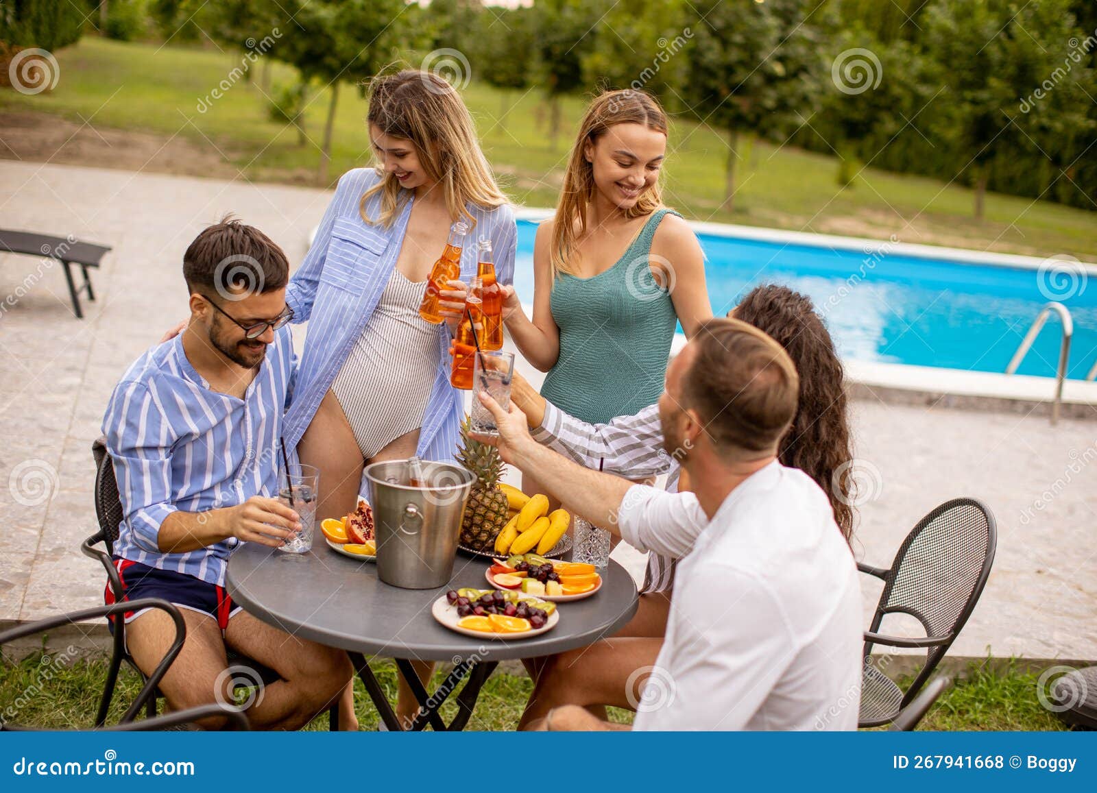 Group of Young People Cheering with Cider by the Pool in the Garden ...