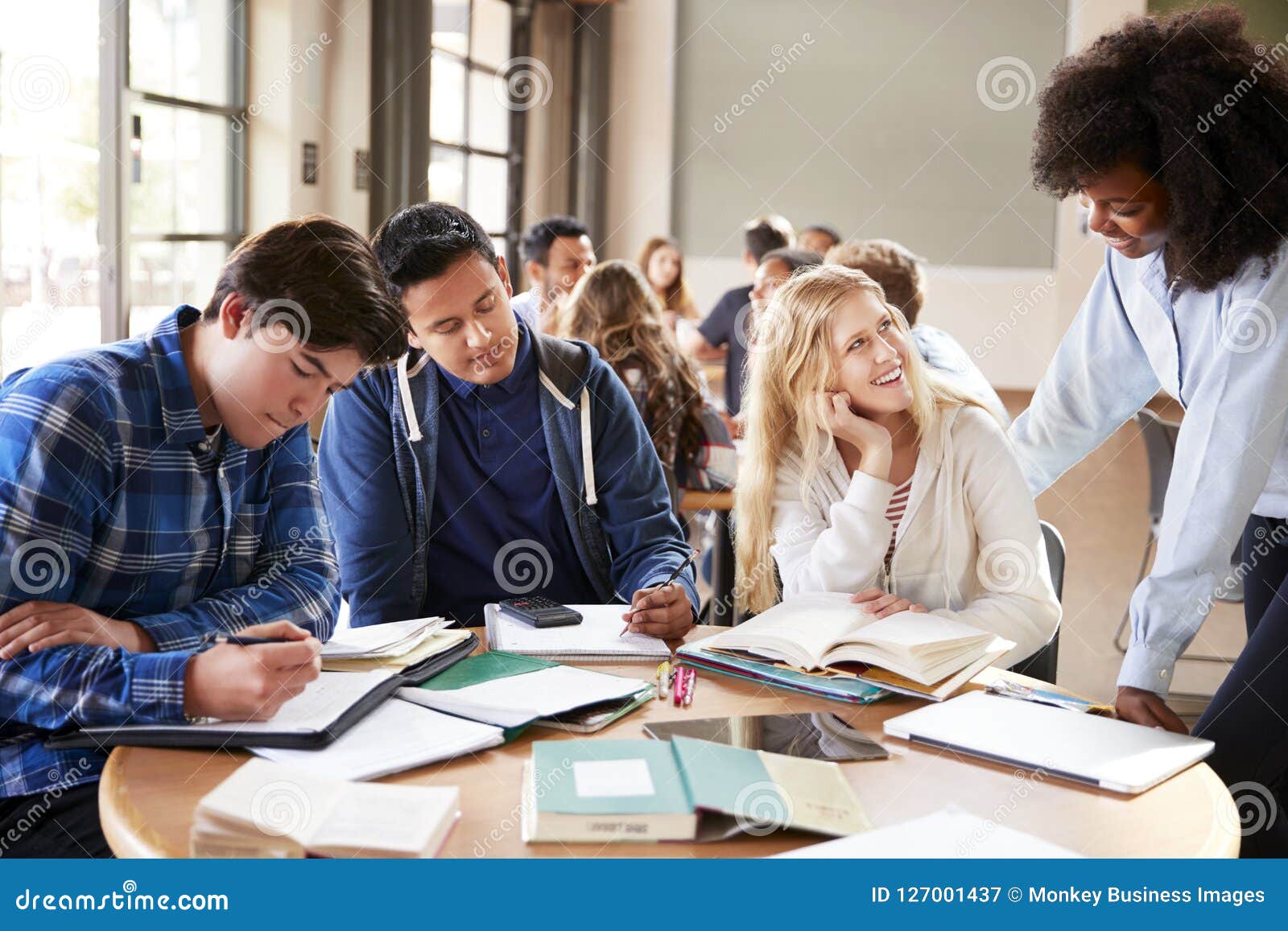 Group of High School Students with Female Teacher Working at Desk Stock ...